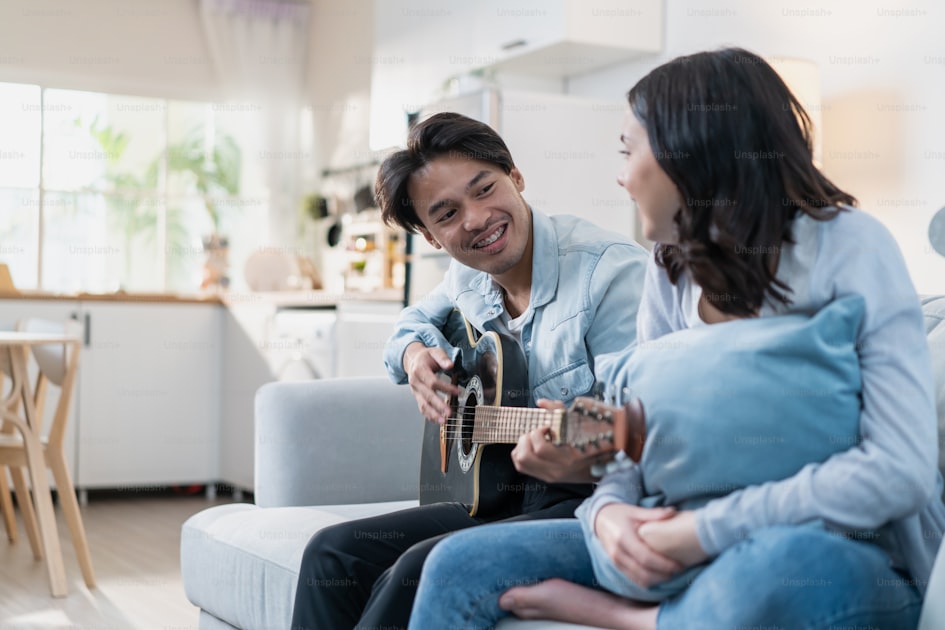 Foto Joven Pareja Amorosa Asiática Toca La Guitarra Juntos En La Sala