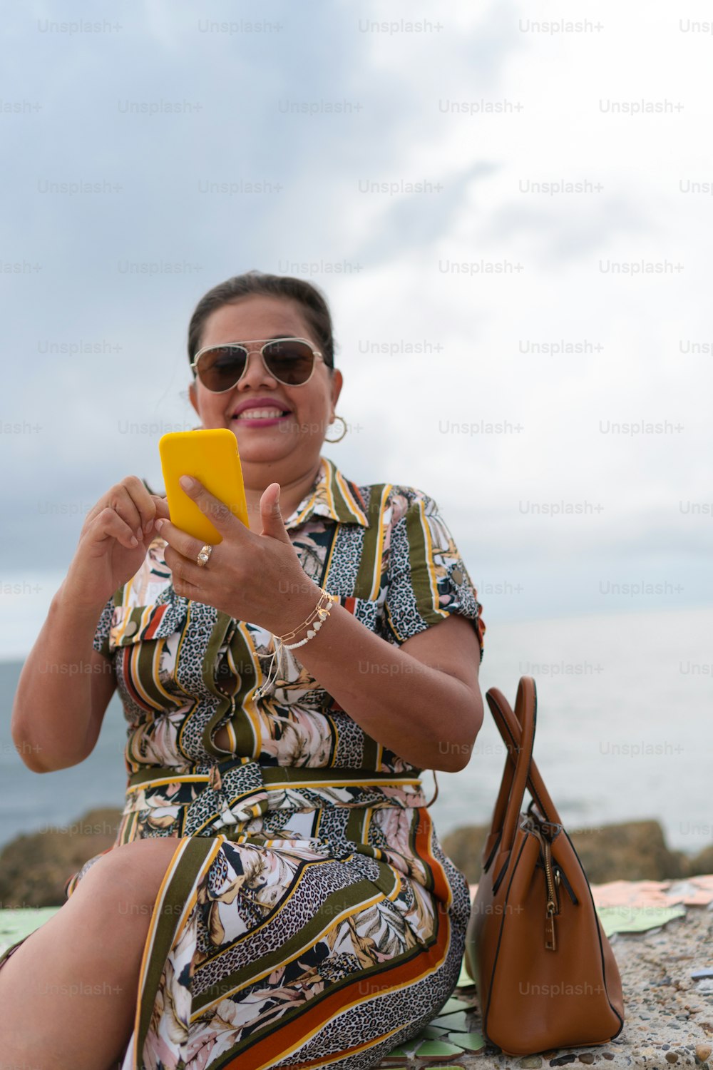 Femme hispanique assise sur un banc vérifiant son téléphone portable ... Femme hispanique assise sur un banc vérifiant son téléphone portable ...