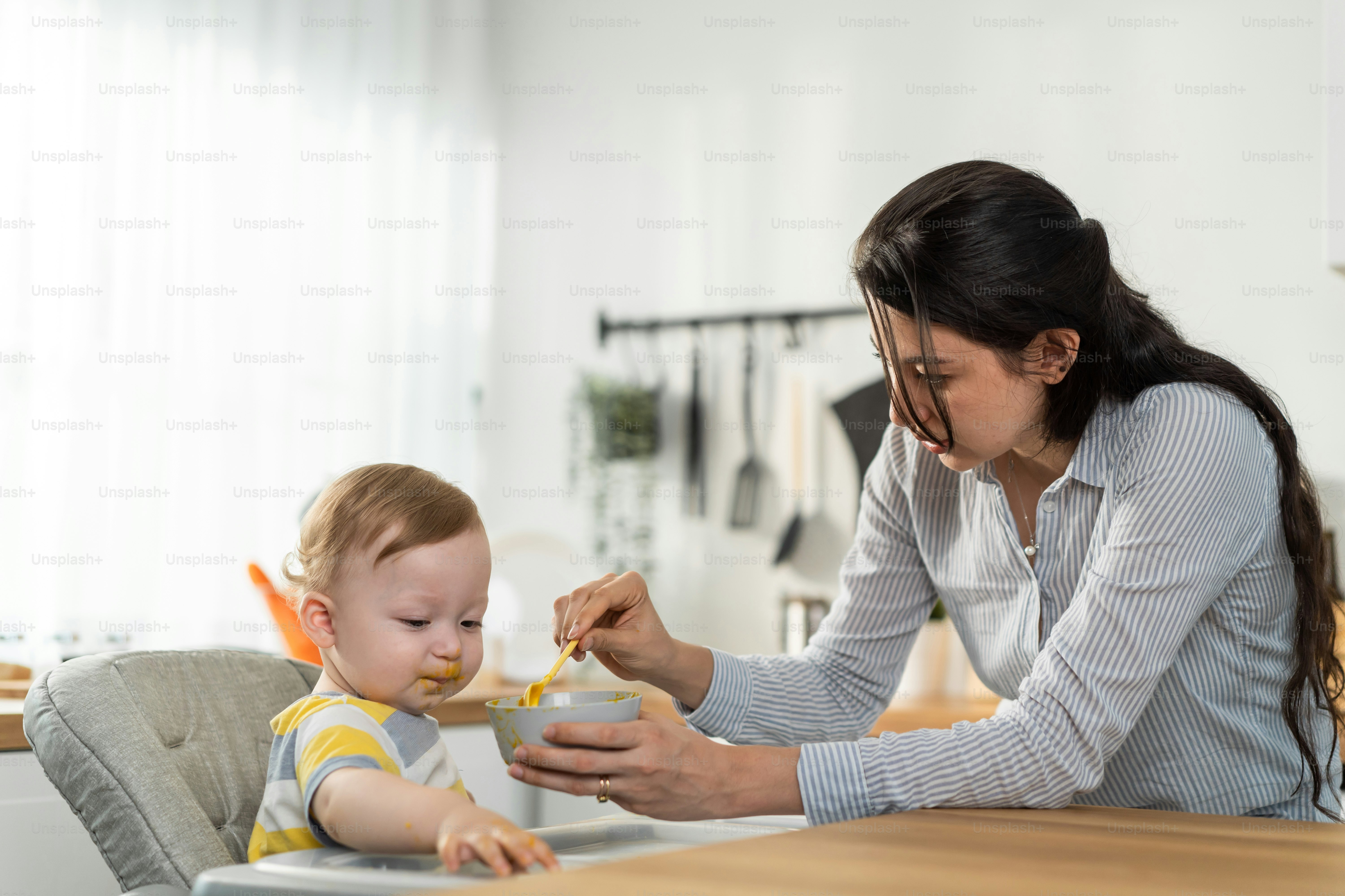 Foto zum Thema Kaukasische schöne Mutter kümmert sich um Baby Junge ...