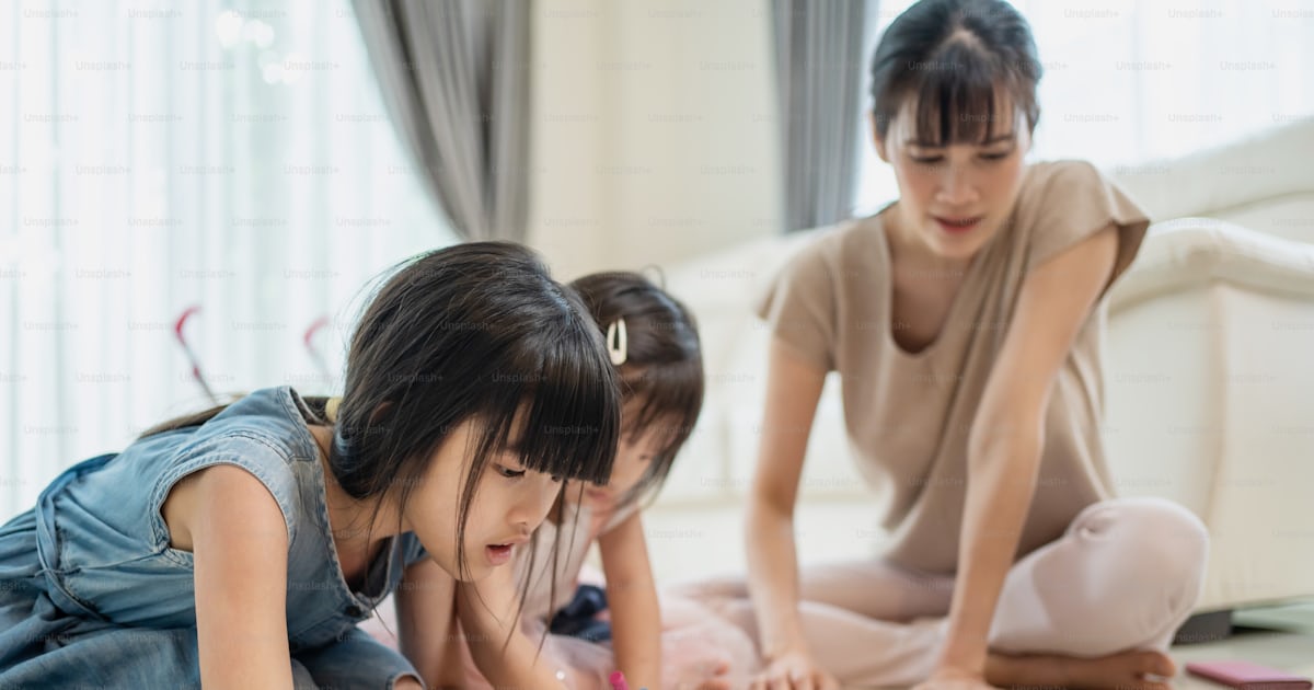 아시아 어린 형제 자매 소녀는 바닥에 어머니와 함께 그림을 그리고 색칠합니다 아름 다운 사랑 부모 엄마는 집에서 활동을