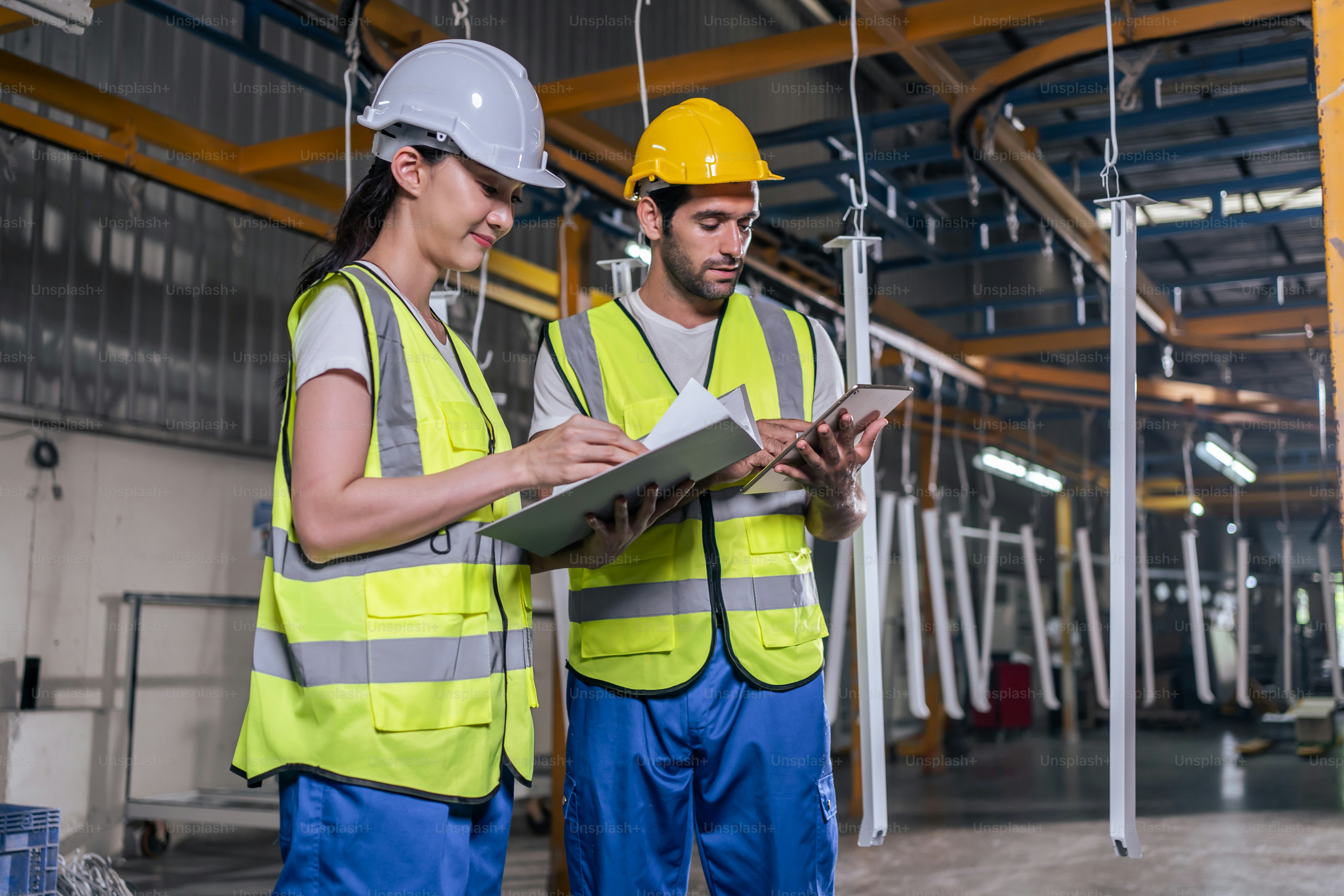Asian male and female industrial worker working in manufacturing plant ...