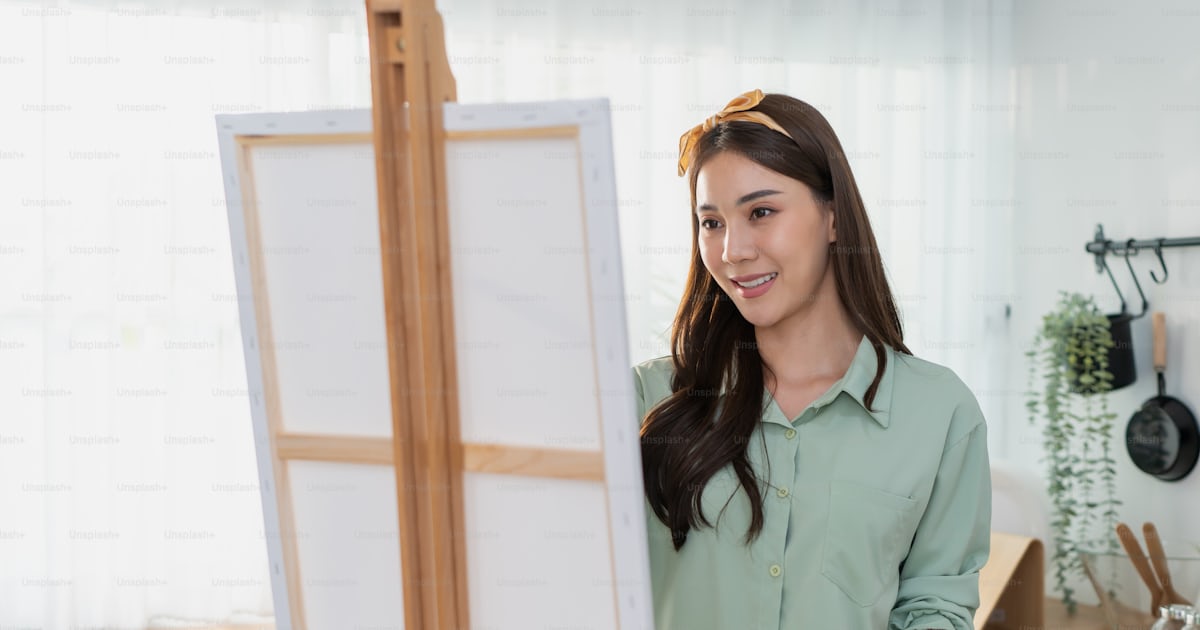 아시아의 젊은 재능 있는 여성 예술가가 집에서 그림 보드에 색칠하고 있다 매력적인 아름다운 여성은 수채화 물감과 브러시로 예술