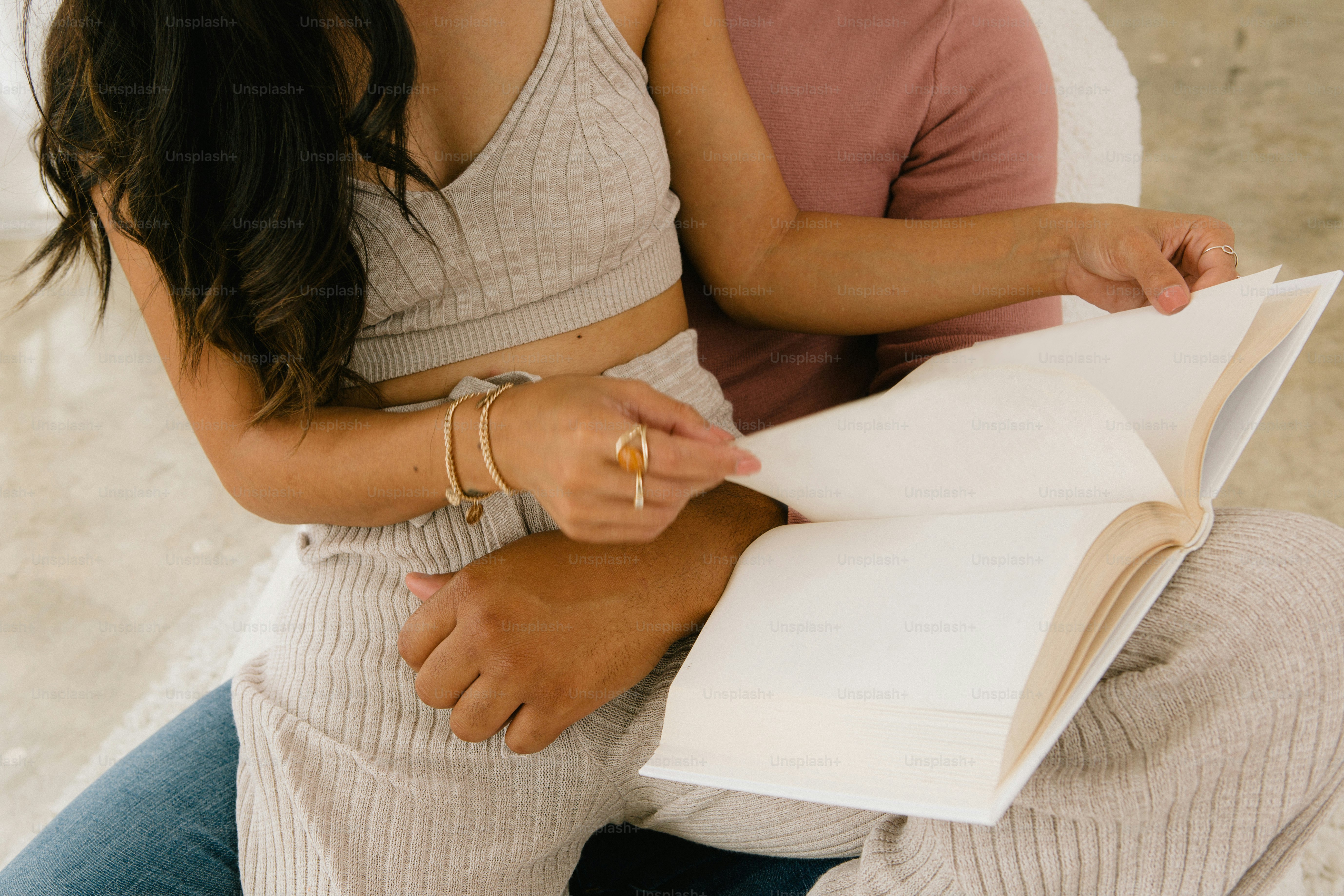 A man and a woman sitting down reading a book photo – High budget Image ...