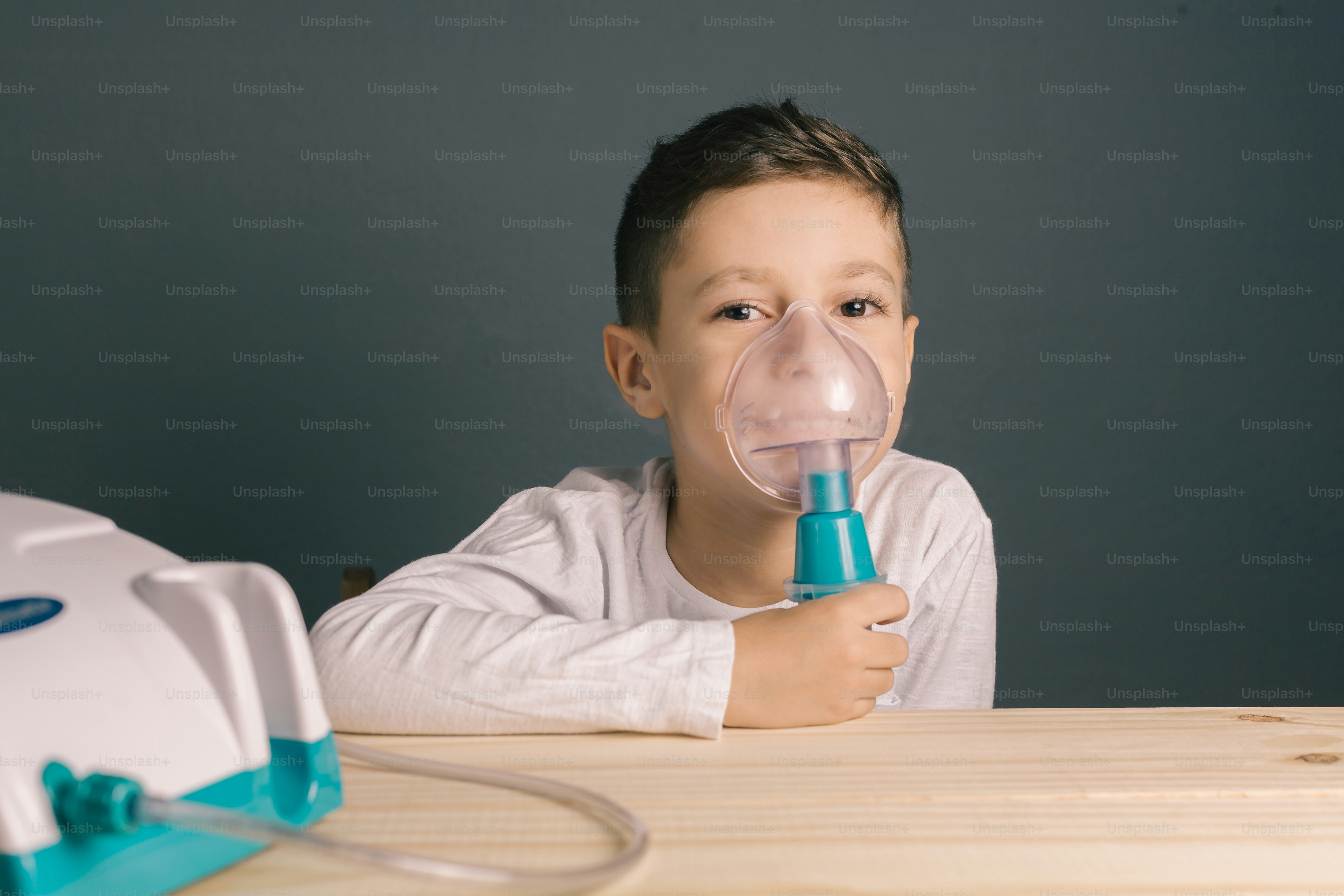 Beautiful sick boy inhalation therapy by the mask of inhaler. Image of ...