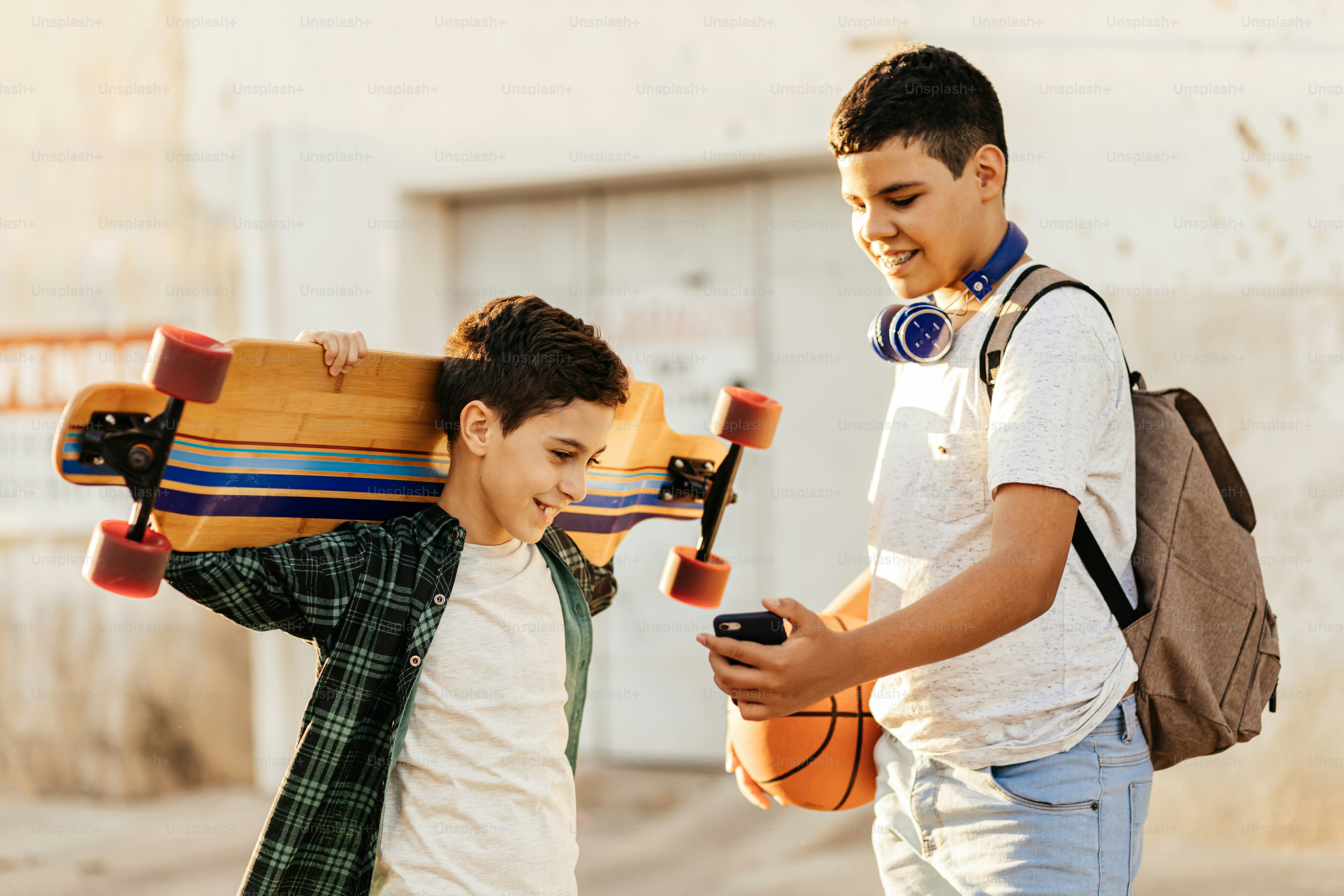Two teenage friends having fun outdoors in the city photo – Long board ...