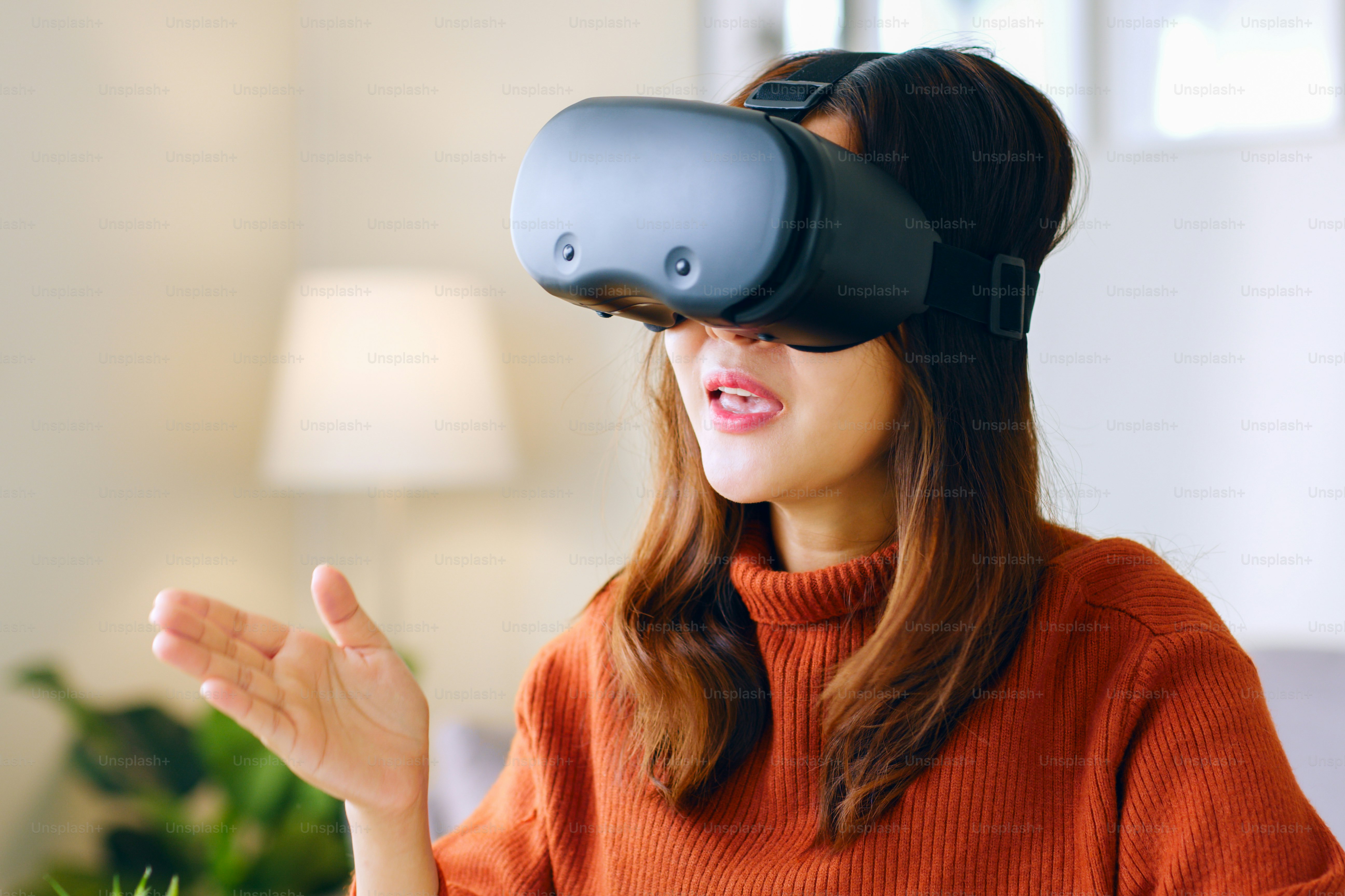 Young Asian woman talking while using 360 VR headset for online meeting ...