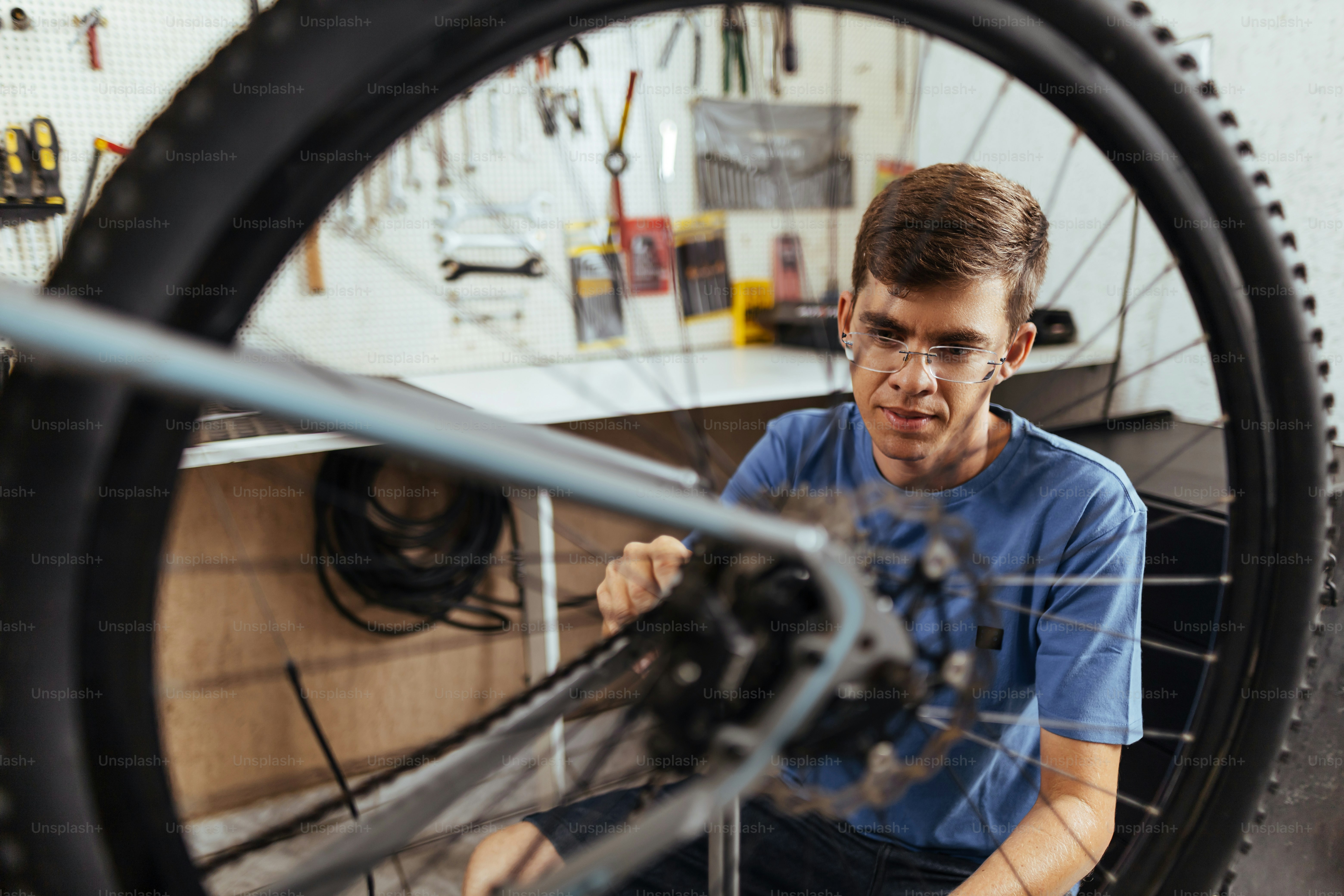 A man working in a bicycle repair shop photo – One man only Image on ...