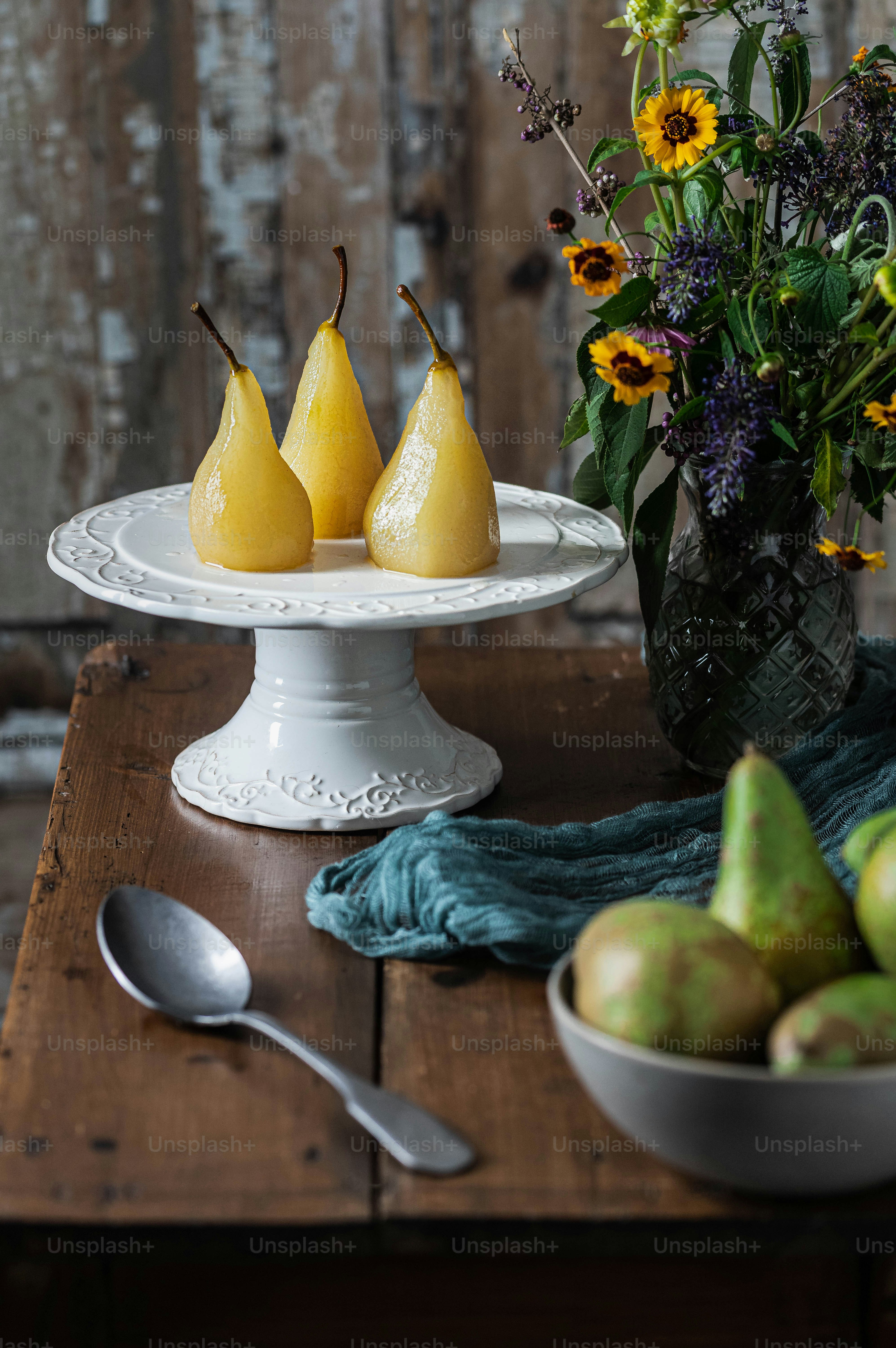 Trois poires et un bol de fleurs sur une table photo – Poire Photo sur ...