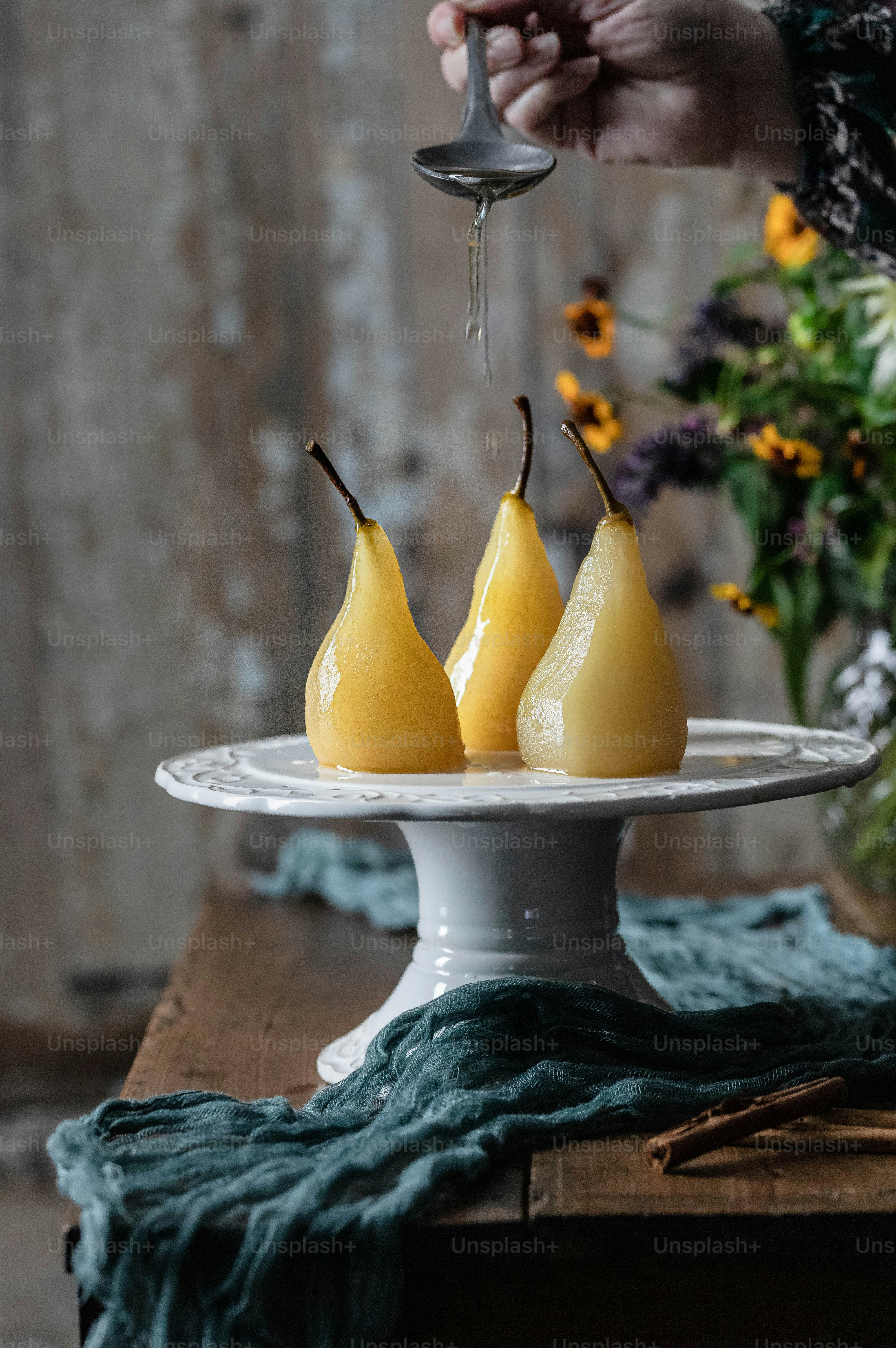 Une assiette blanche surmontée de trois poires sur le dessus d’une ...