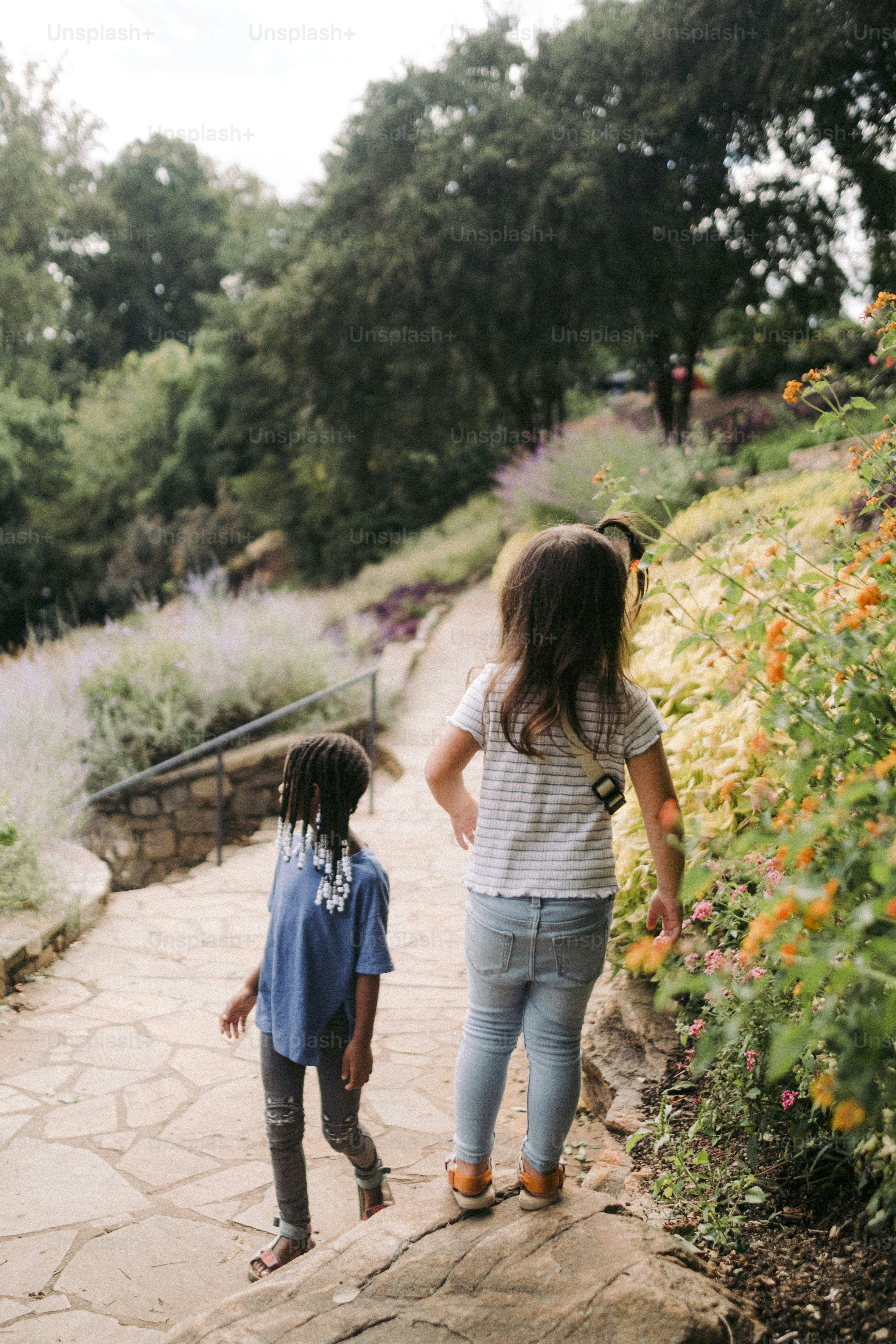 A little girl and a little girl walking down a path photo – Outdoors ...
