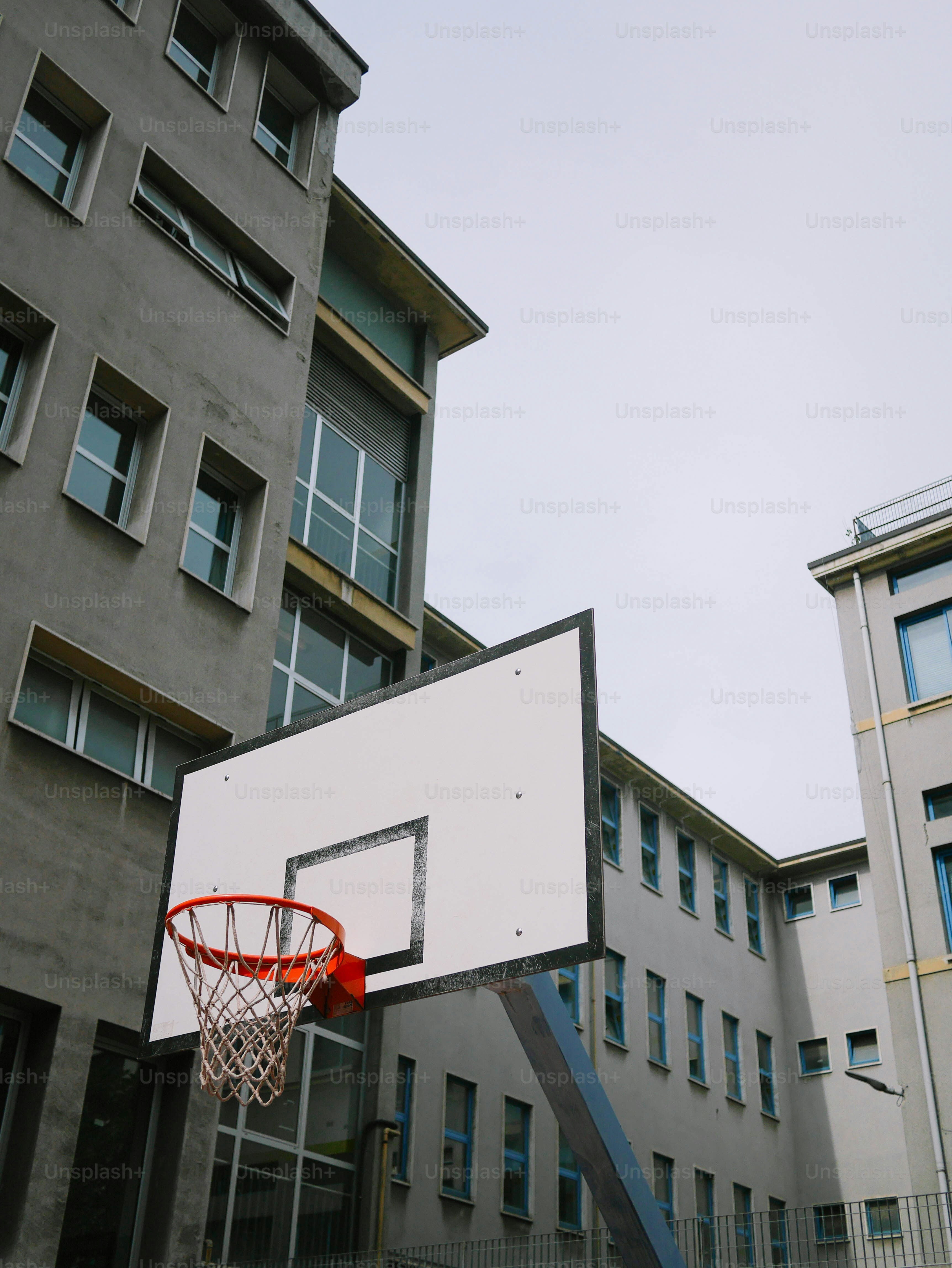 A basketball hoop in front of a building photo – Basketball hoop Image ...