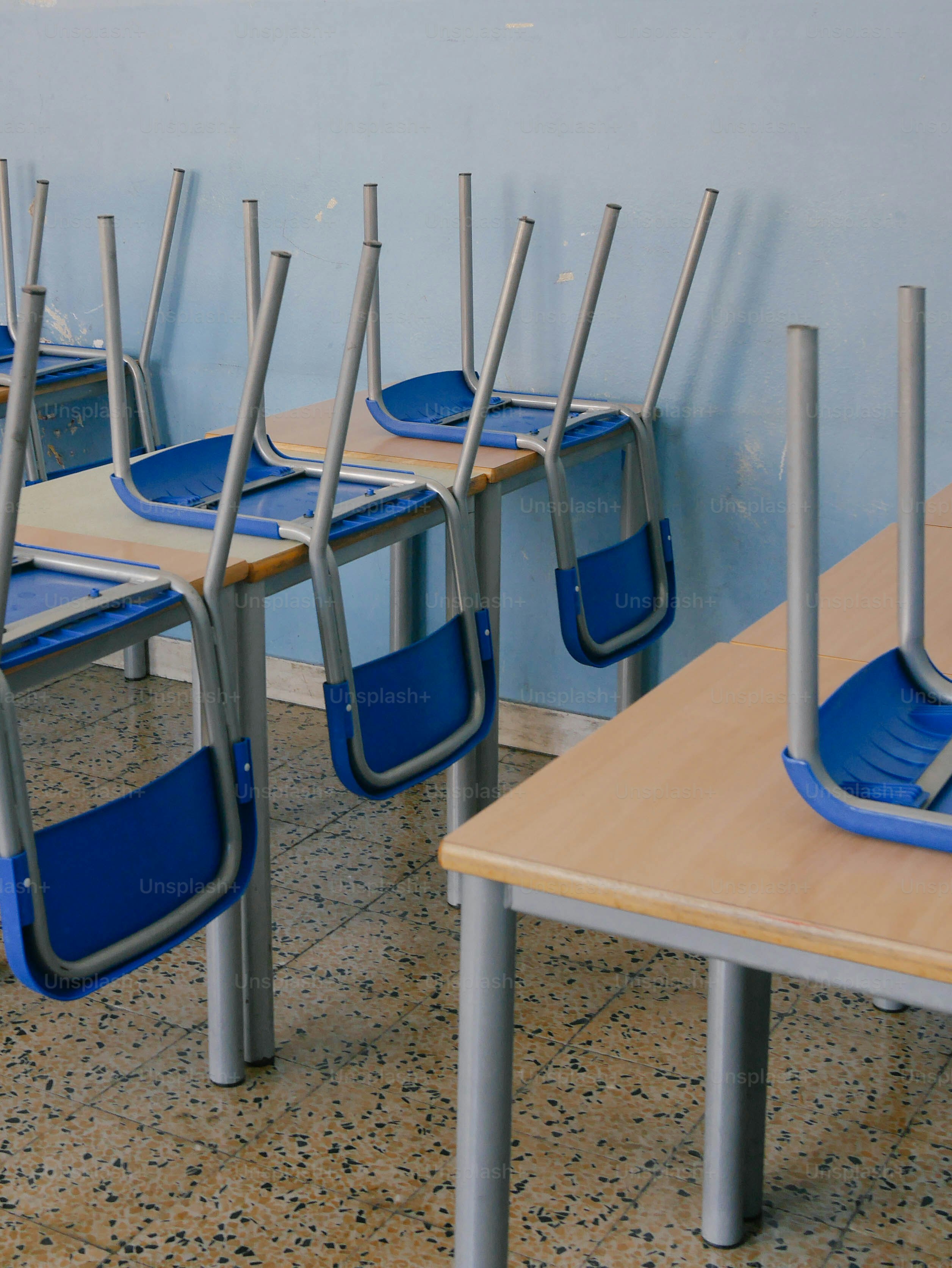 A row of desks with blue trays on top of them photo – College Image on ...