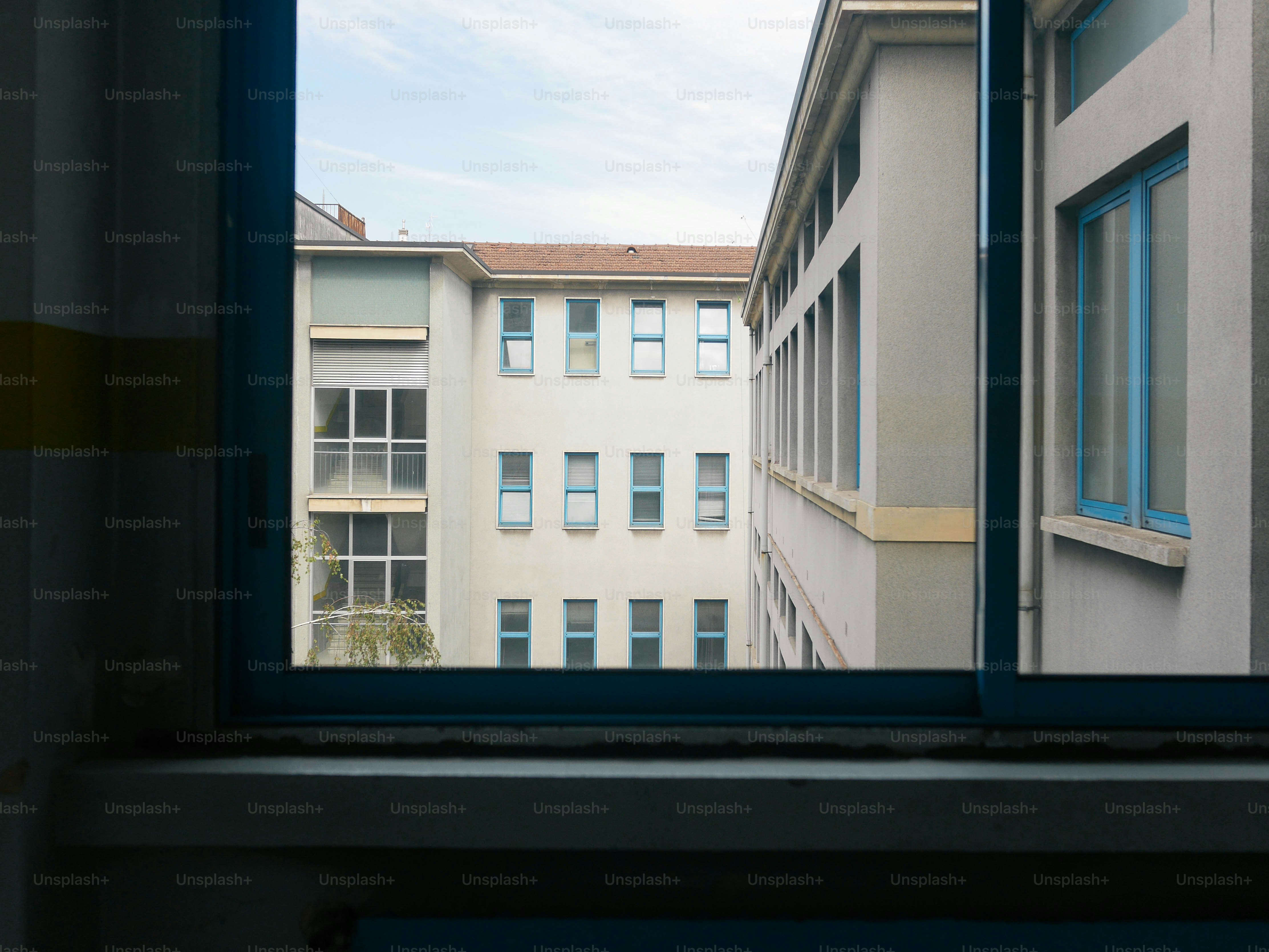 A view of a building through a window photo – College building Image on ...