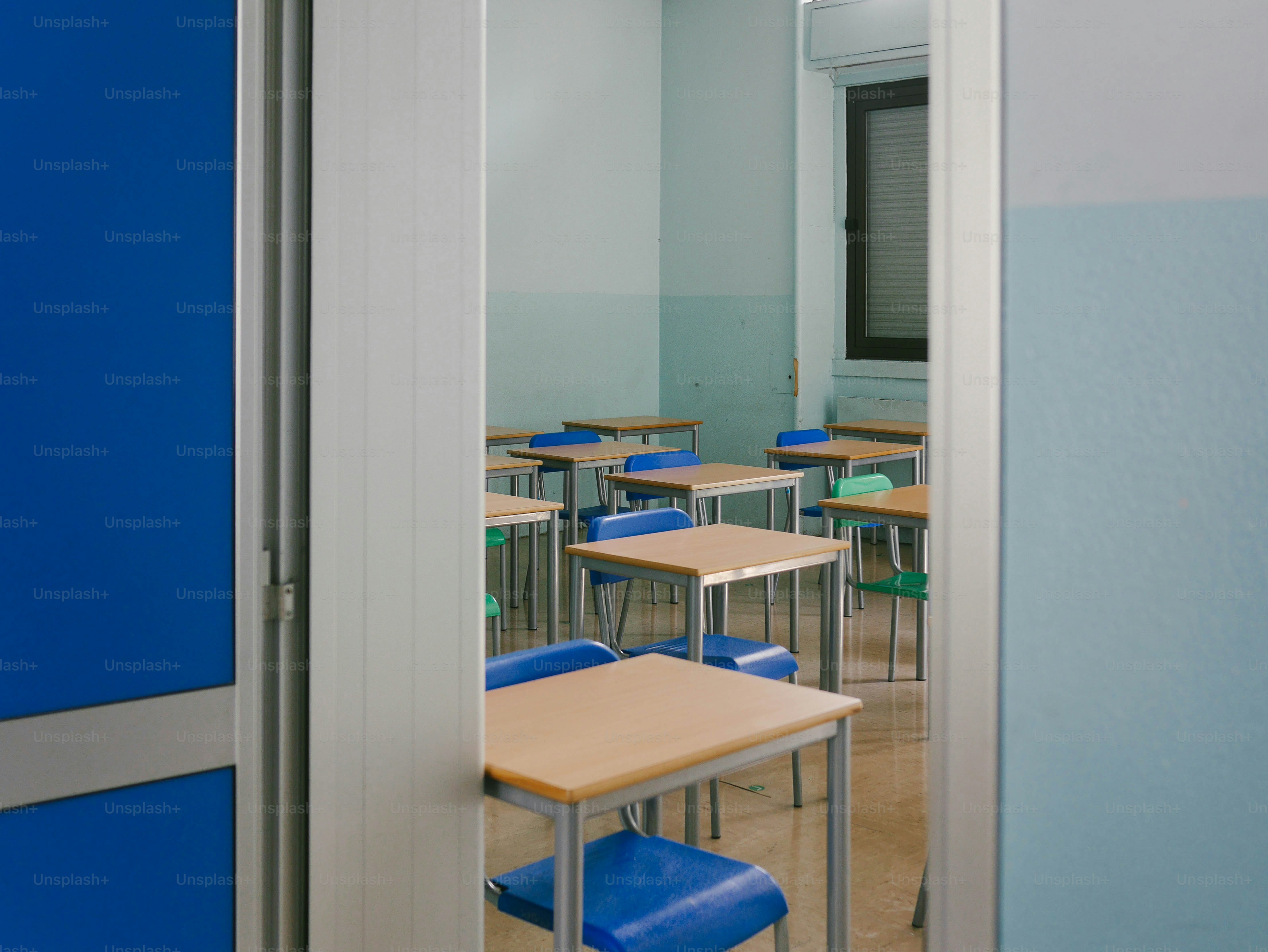 A classroom with blue and white walls and desks photo – School Image on ...
