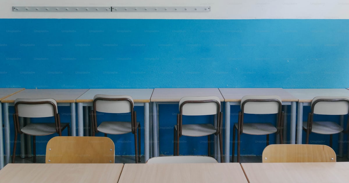 파란 벽 앞에 줄지어 앉아 있는 의자들 사진 Unsplash의 학교 교실 이미지