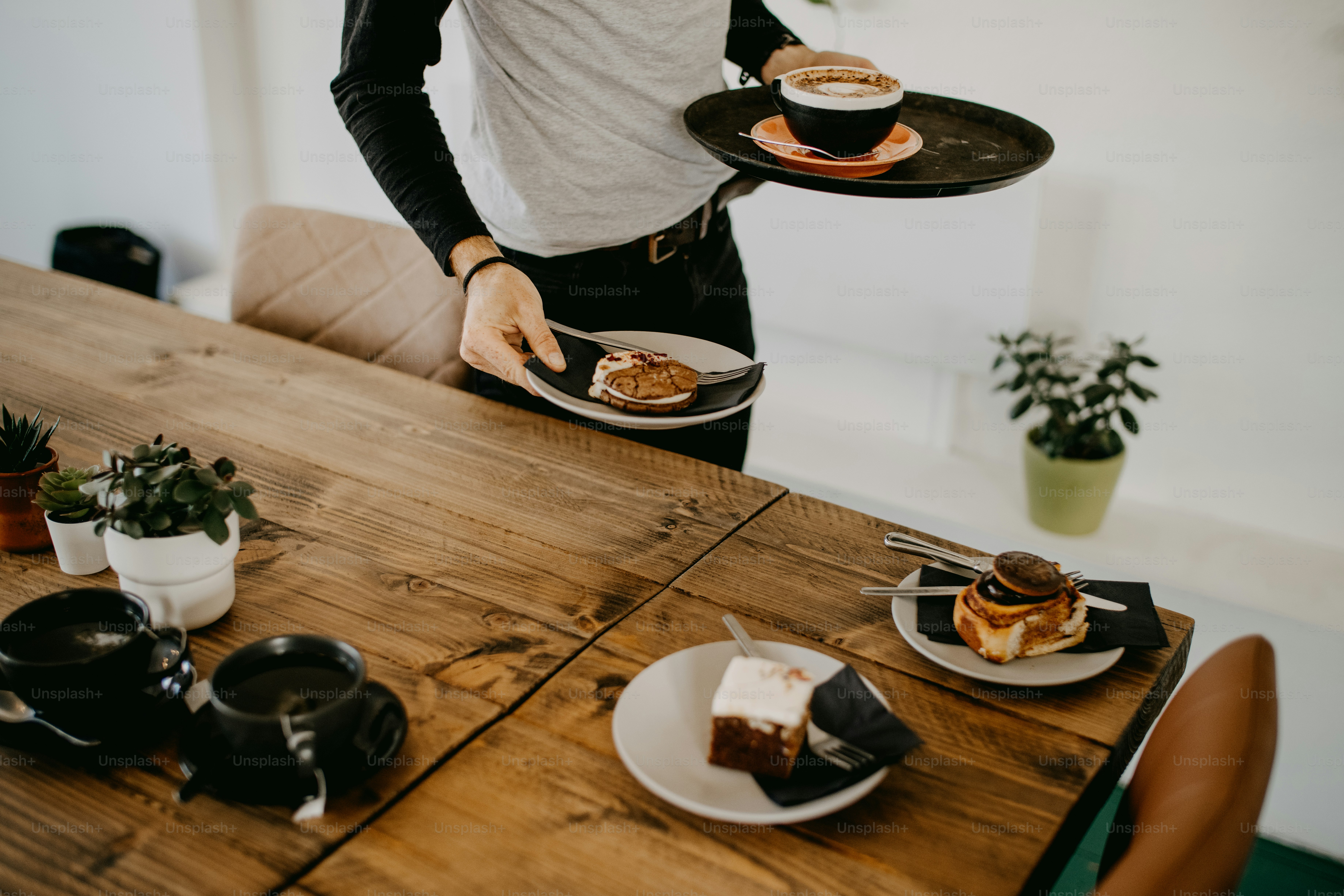 Man holding two plates of food on a wooden table photo – Professional ...