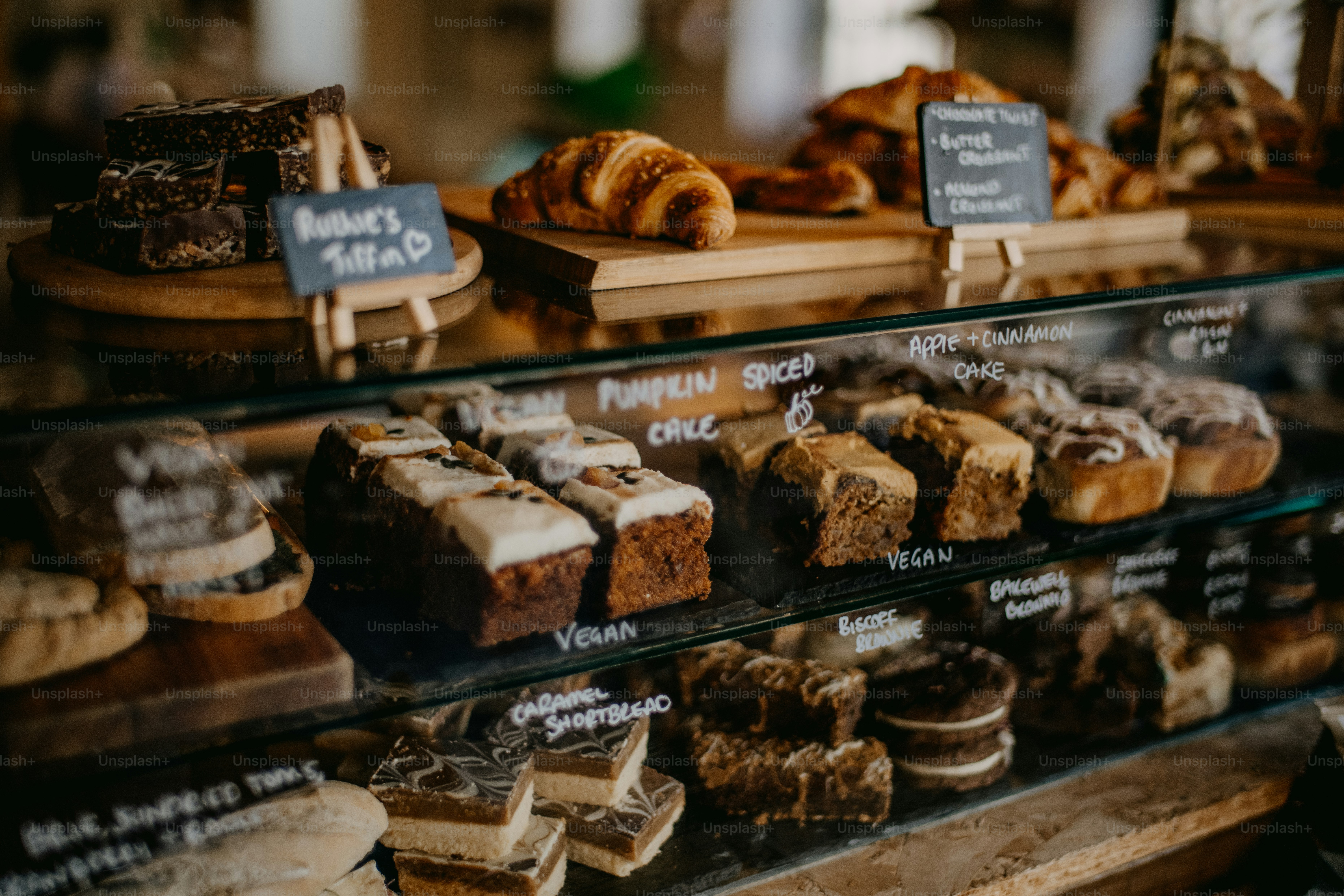 A display case filled with lots of different types of cakes photo ...