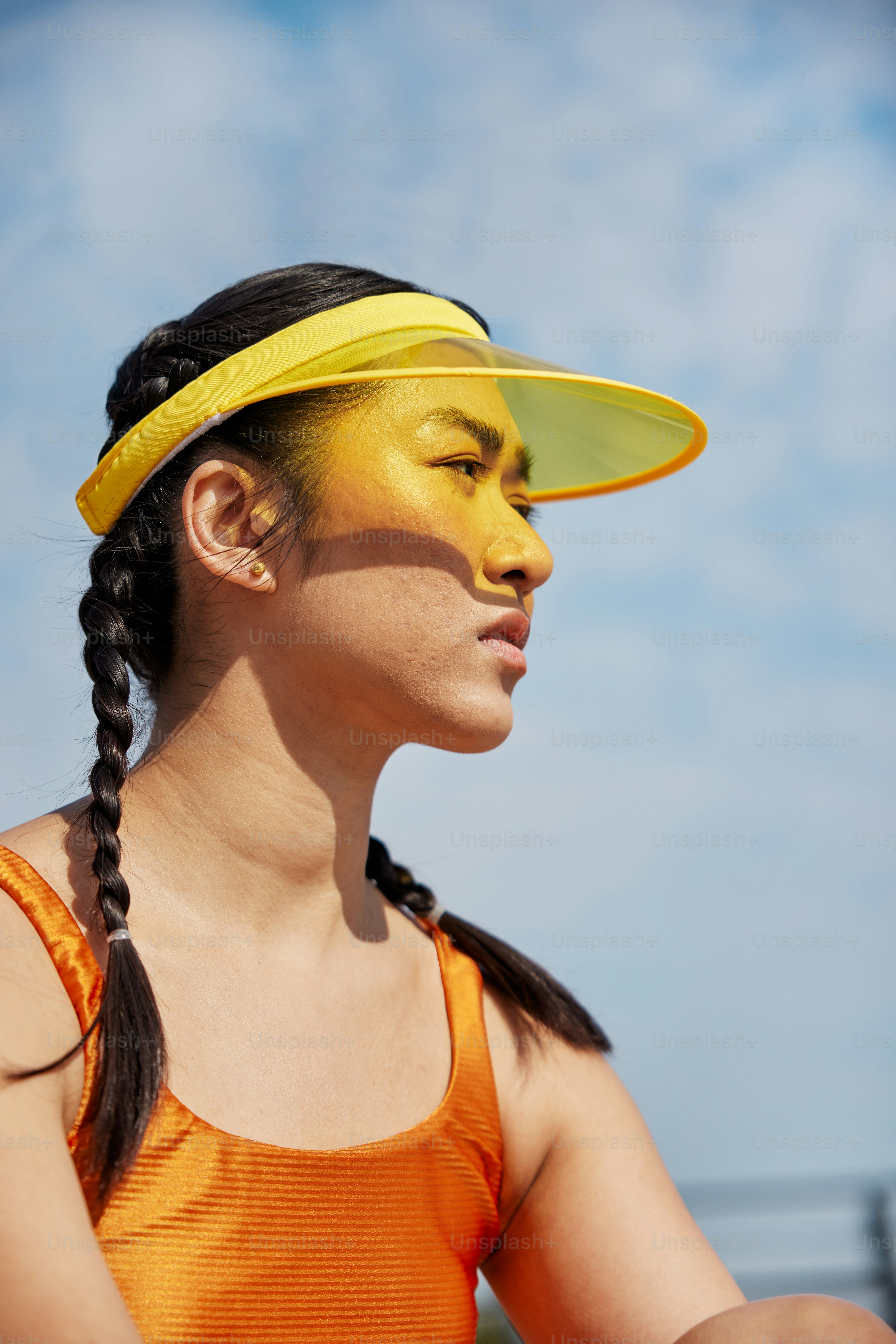 A woman with a yellow frisbee on her head photo – Warming up Image on ...