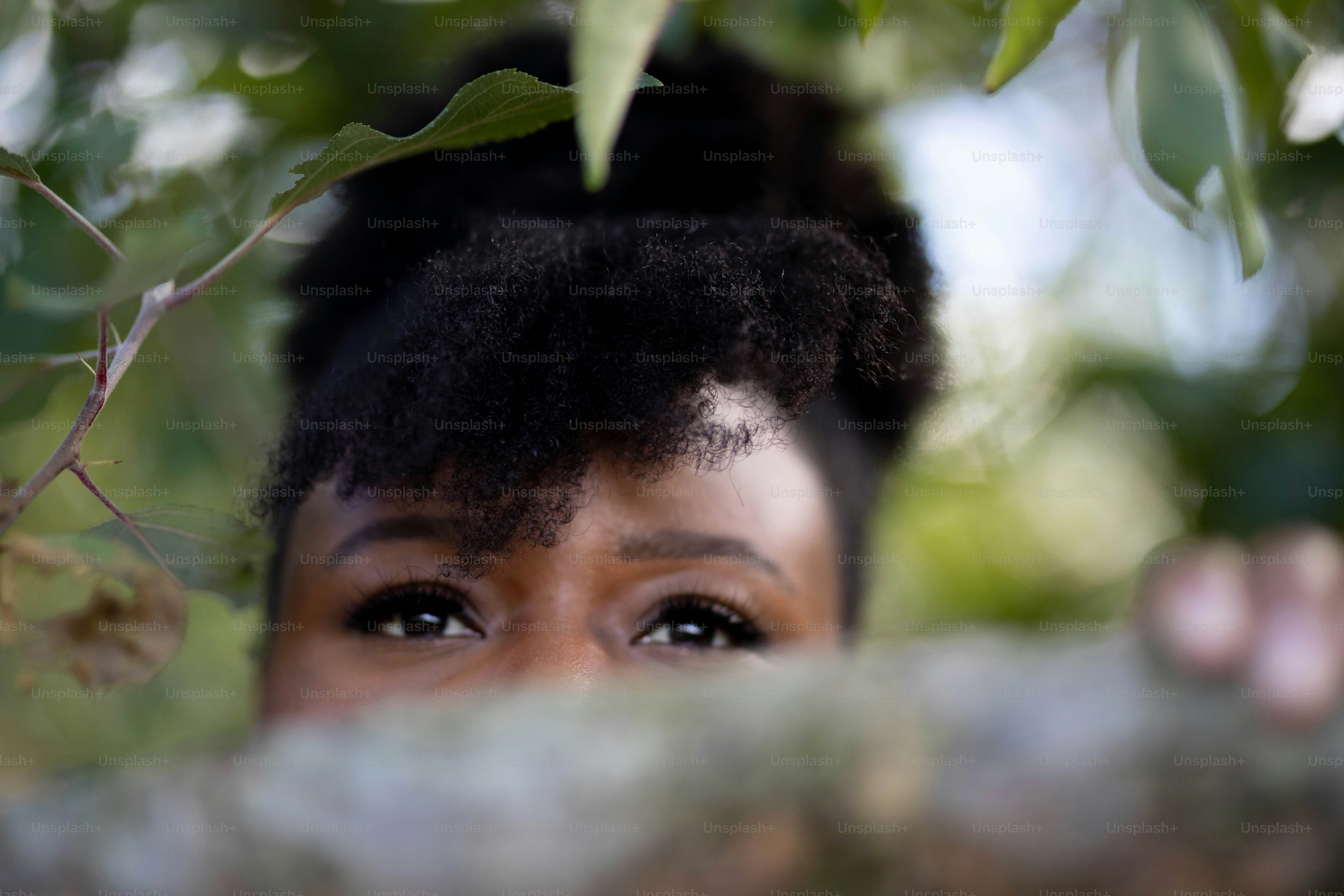 A close up of a person peeking out from behind a tree photo – Eyes ...