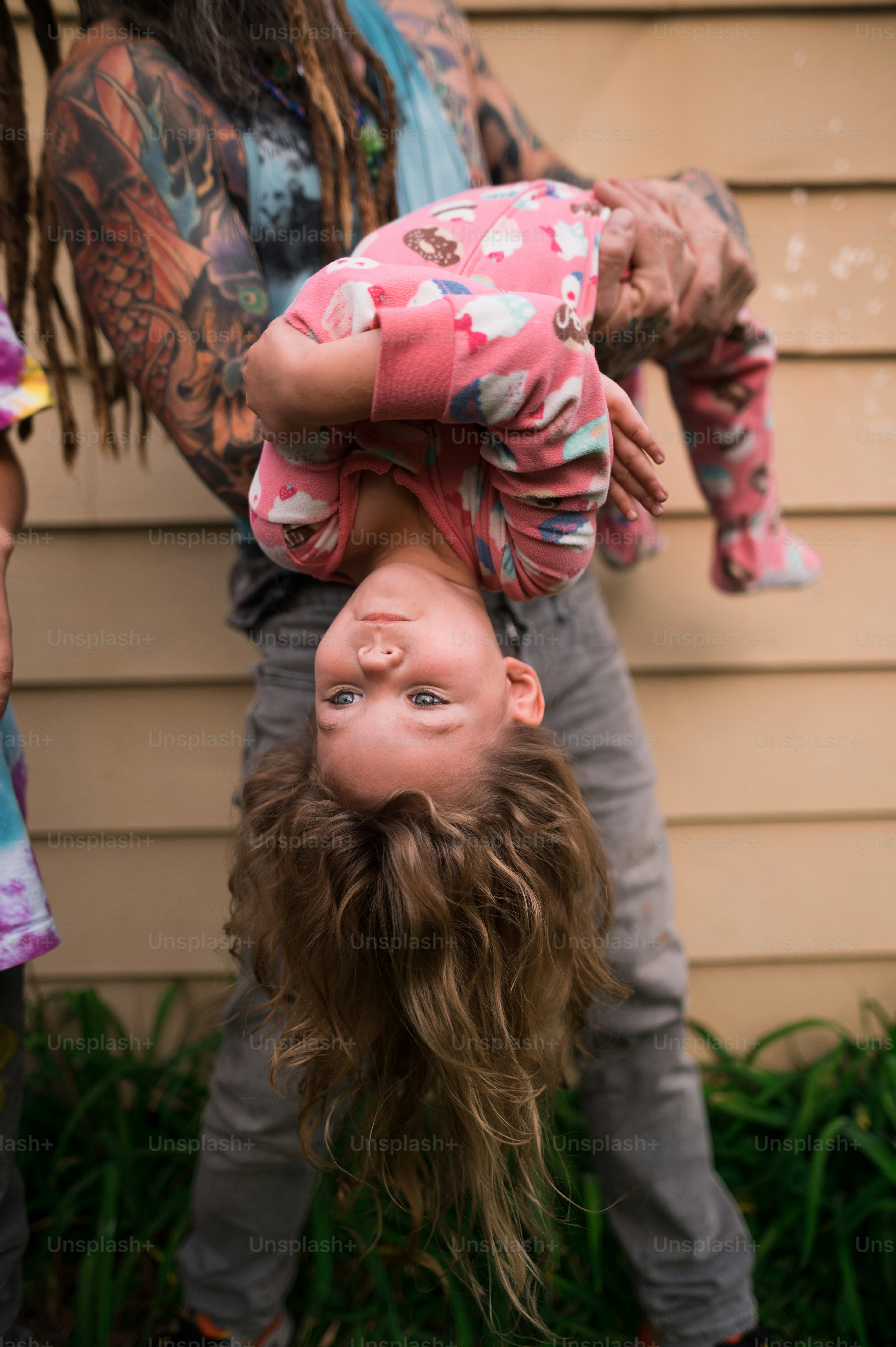 A woman holding a child upside down on her head photo – Upside down ...