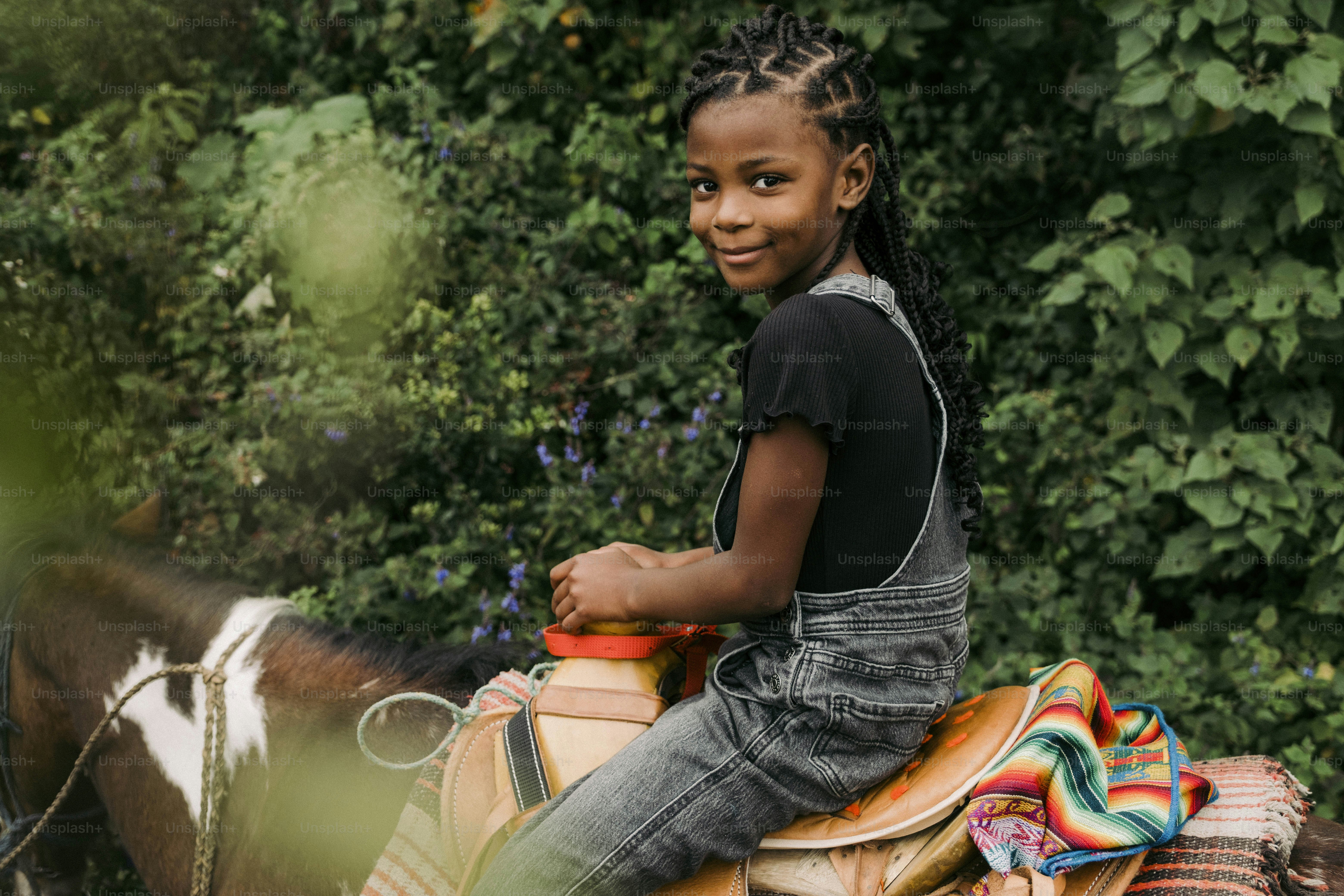 A young girl sitting on a horse in the woods photo – Tween Image on ...