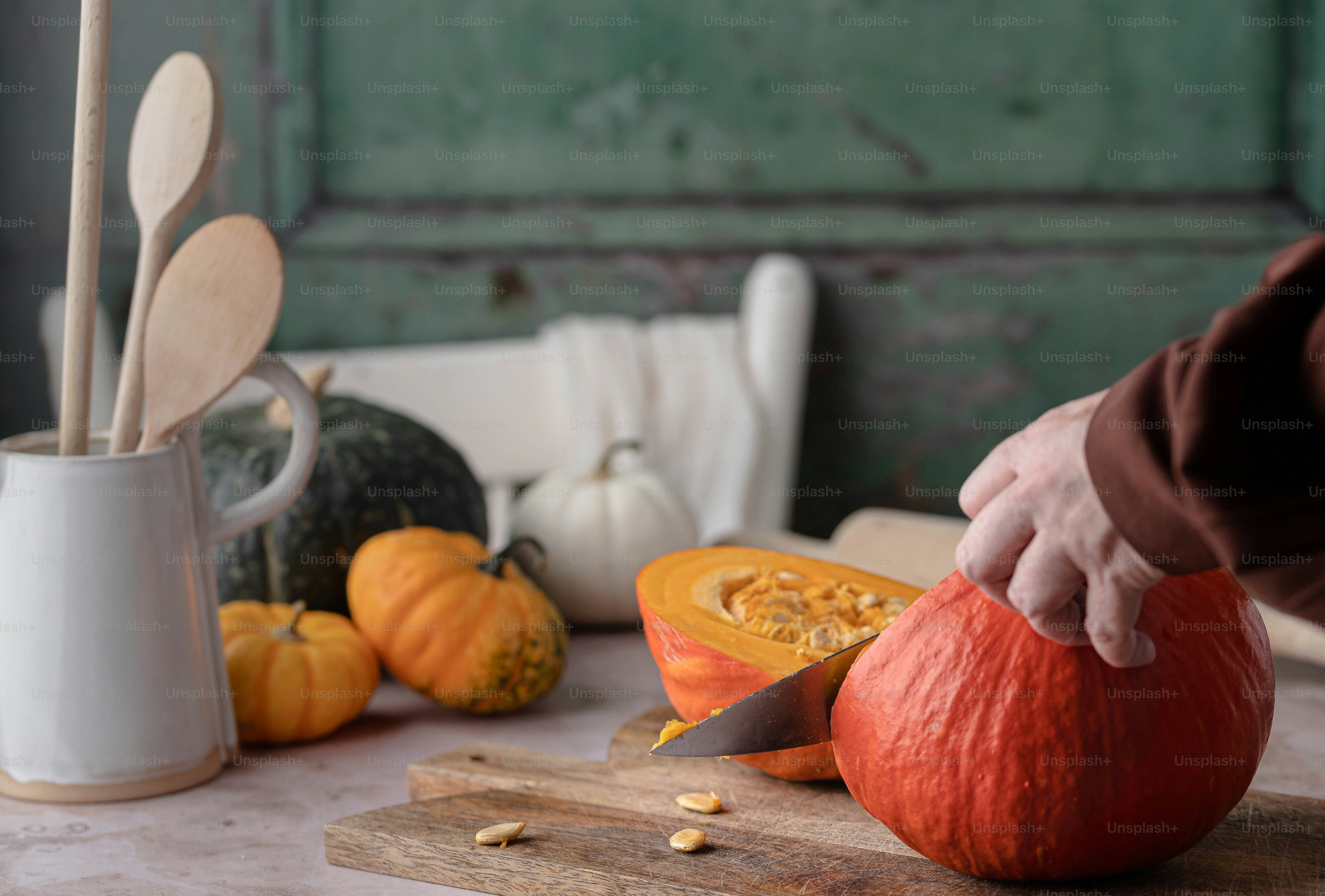 A person slicing a pumpkin on a cutting board photo – Sliced pumpkin ...