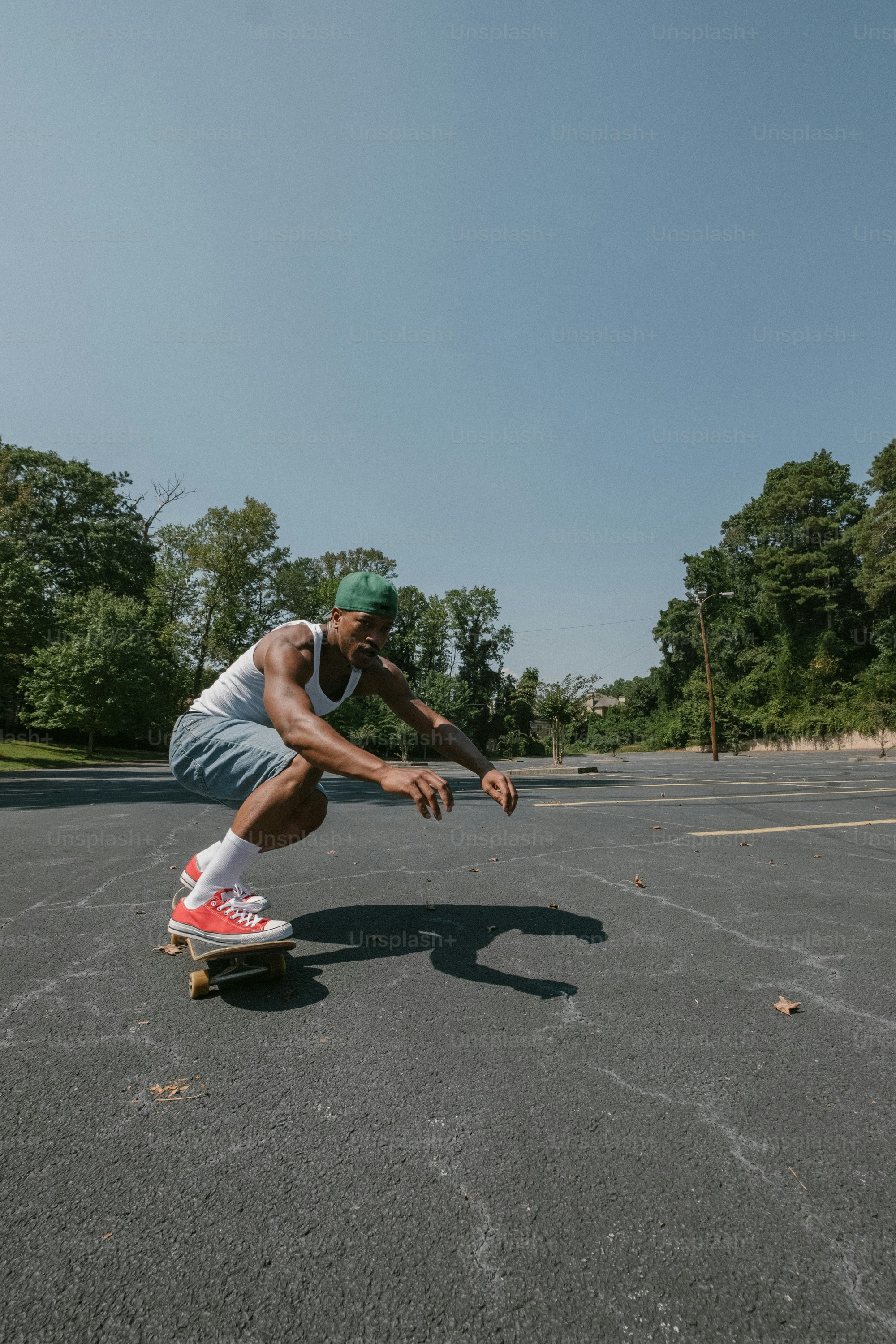 A man riding a skateboard across a parking lot photo – At the skate ...