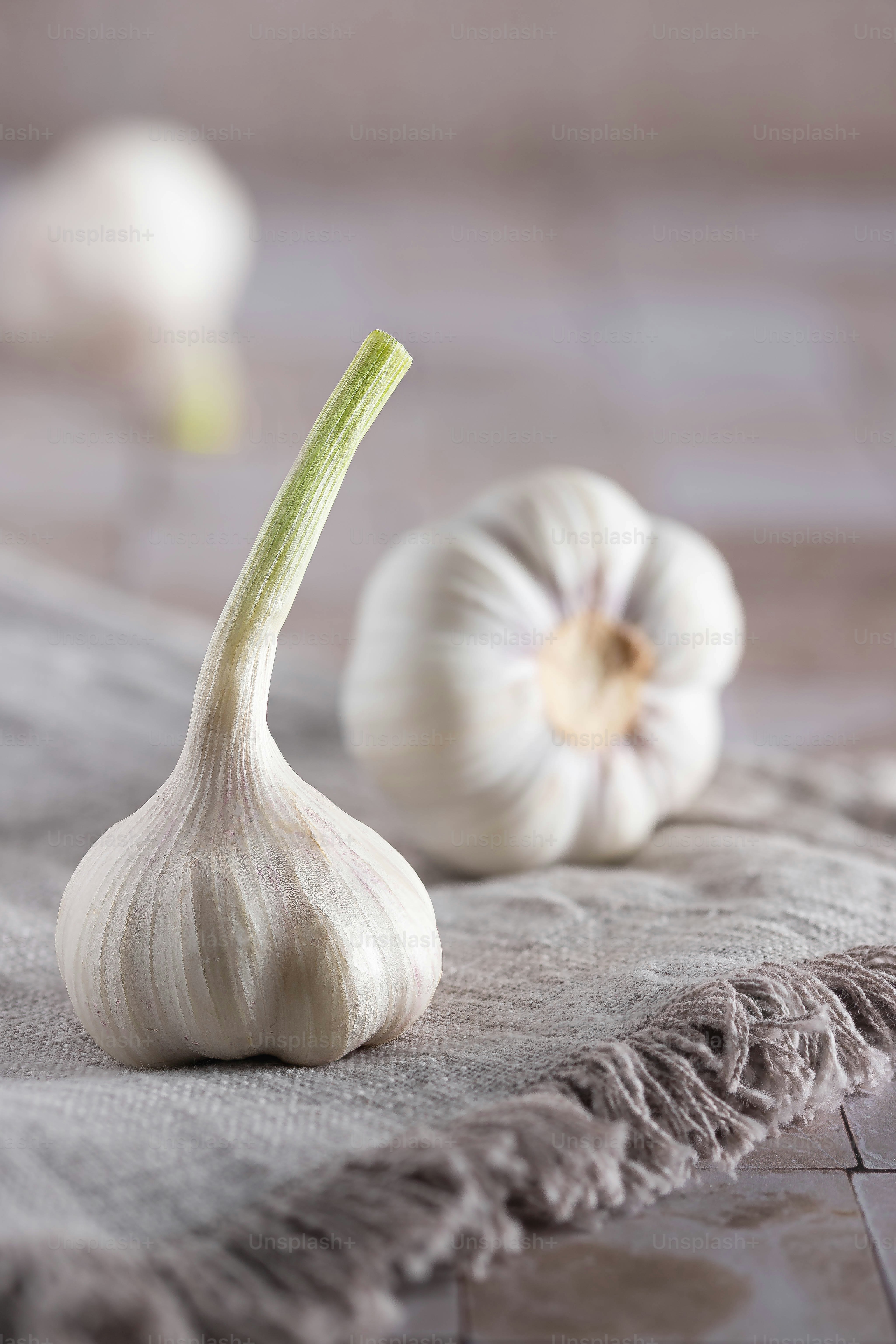A couple of garlics sitting on top of a table photo – Garlic Image on ...