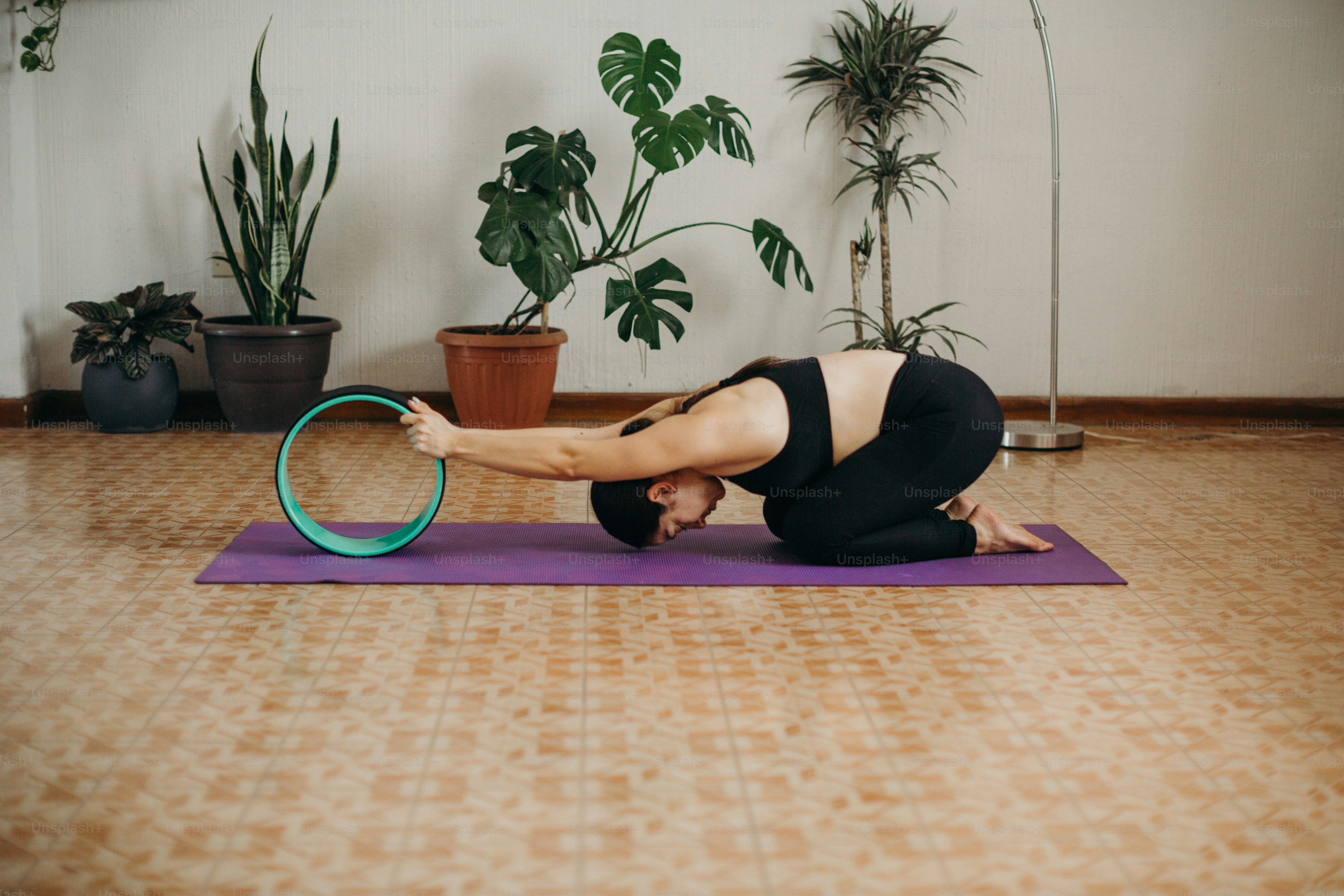 A woman is doing a yoga pose on a mat photo – Indoor Image on Unsplash