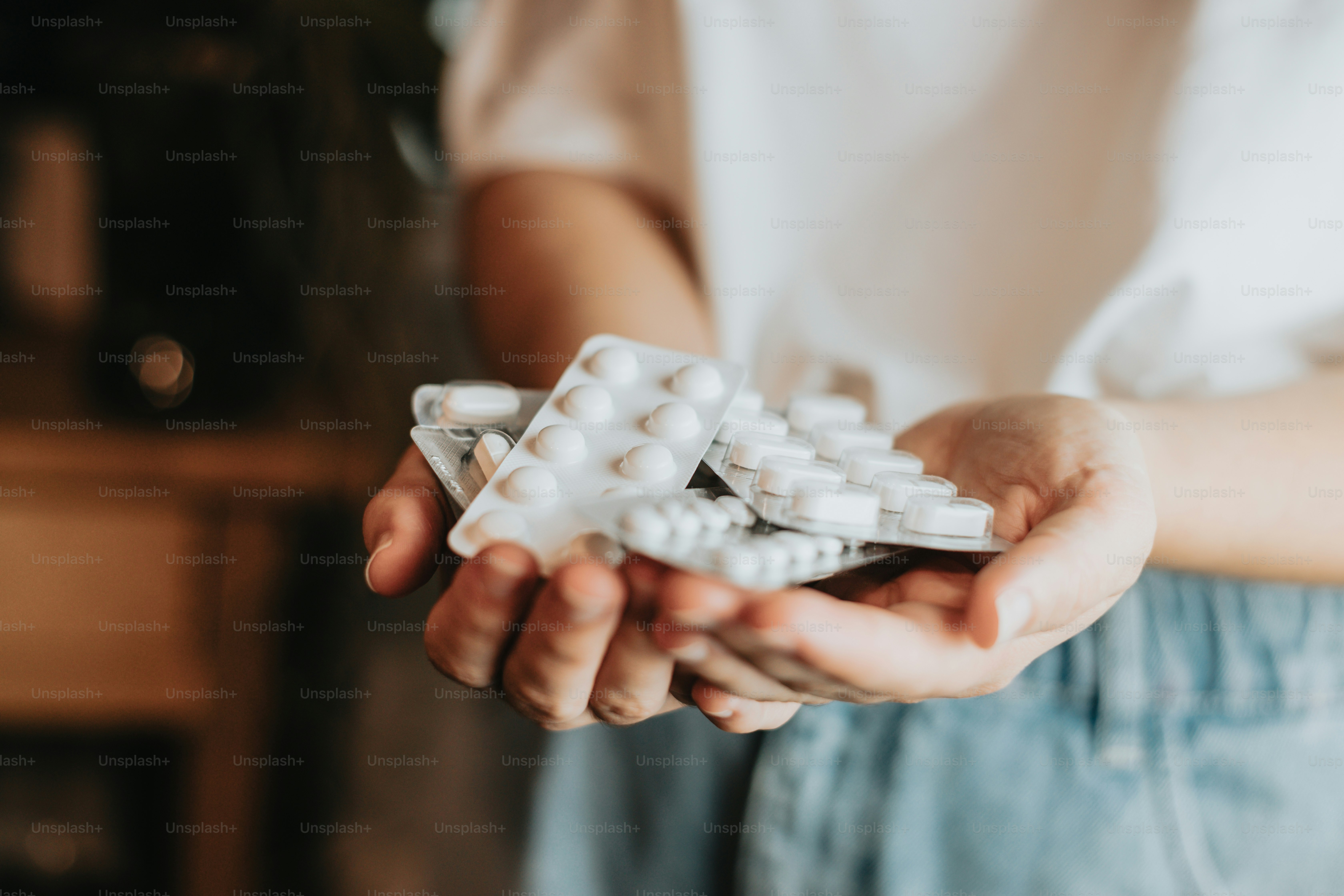 A person holding a bunch of pills in their hands photo – Medication ...