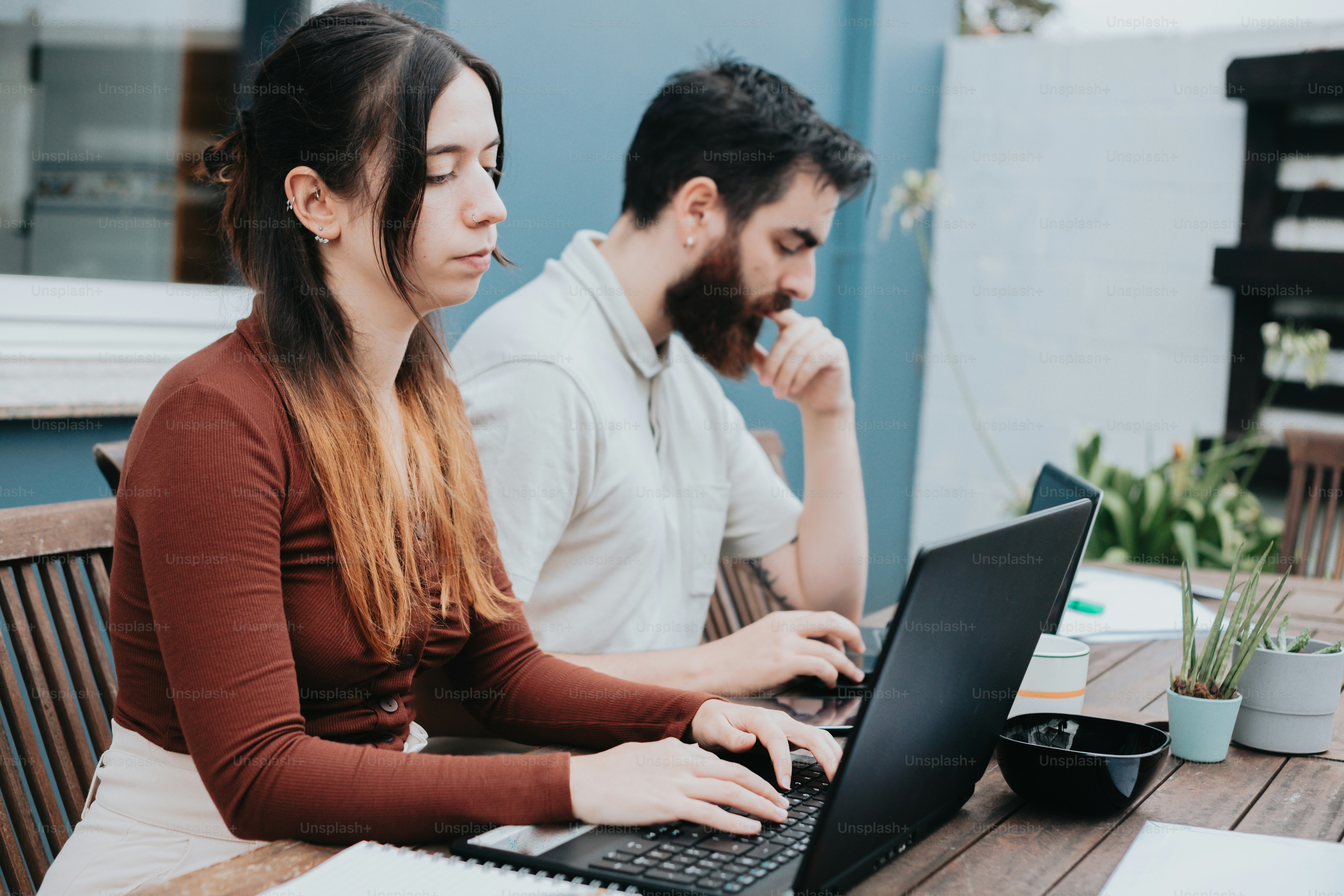 A man and a woman sitting at a table with a laptop photo – Job Image on Unsplash