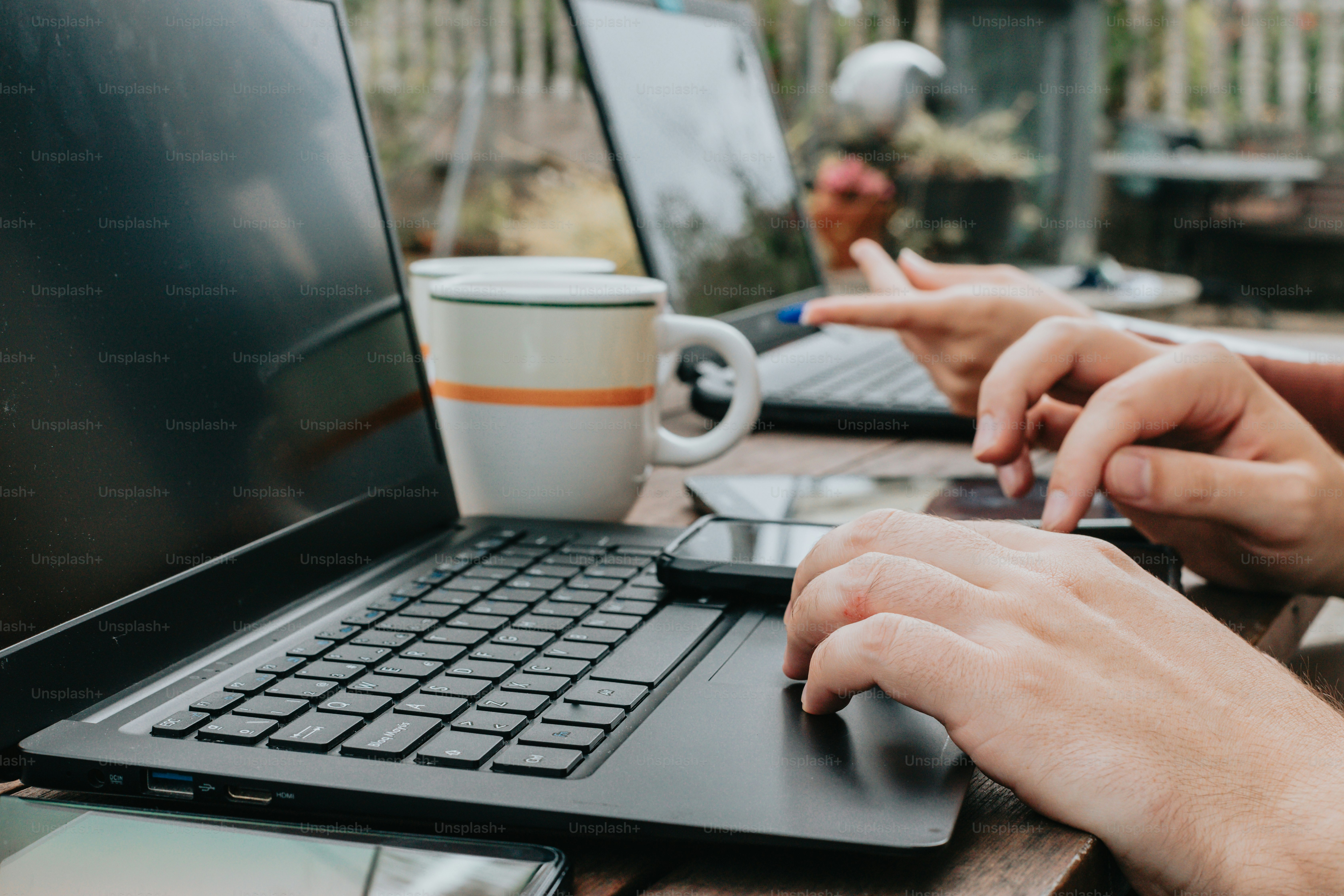 A person using a laptop on a wooden table photo – Laptop Image on Unsplash