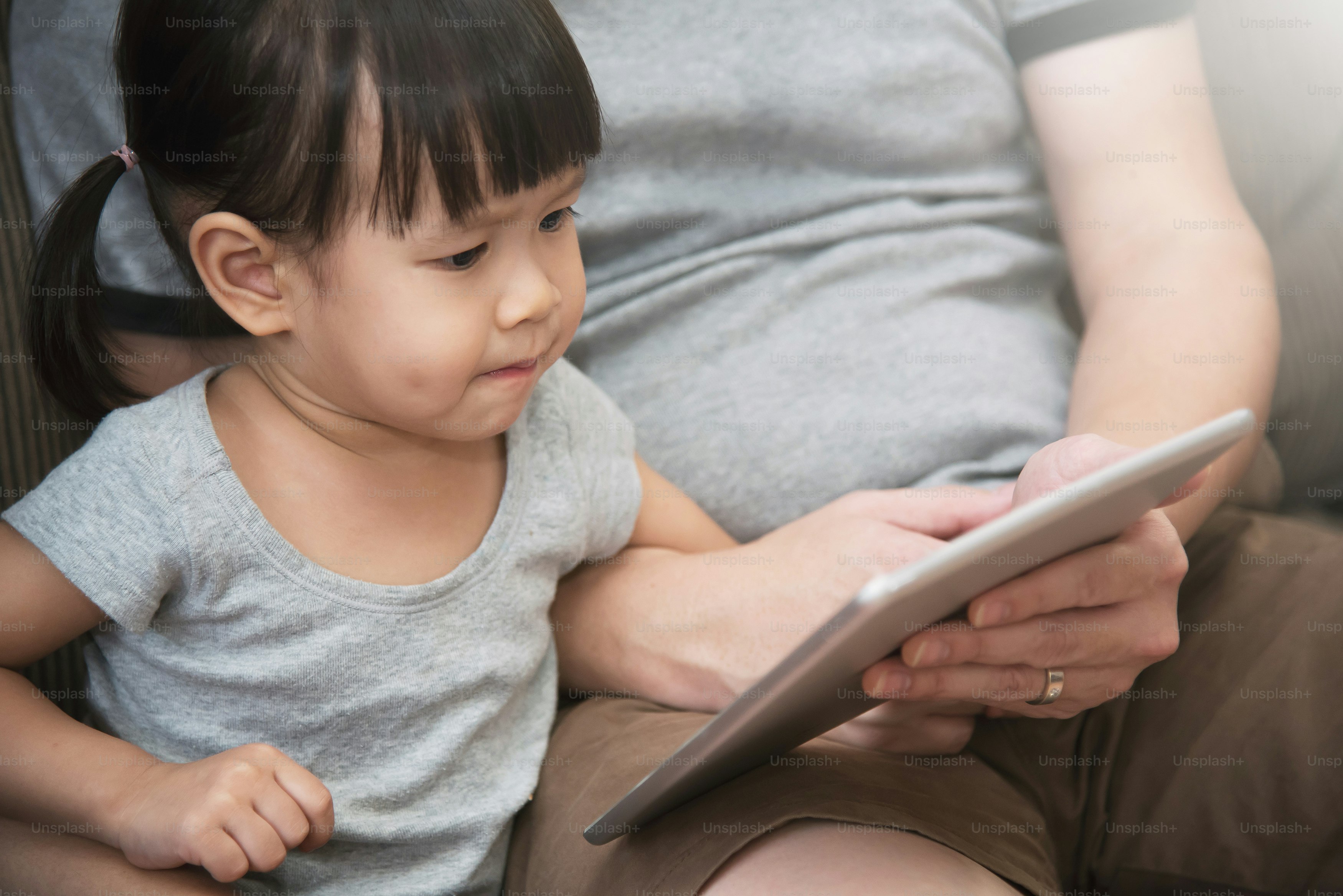 Asian little kid girl and her father sitting and using digital tablet ...