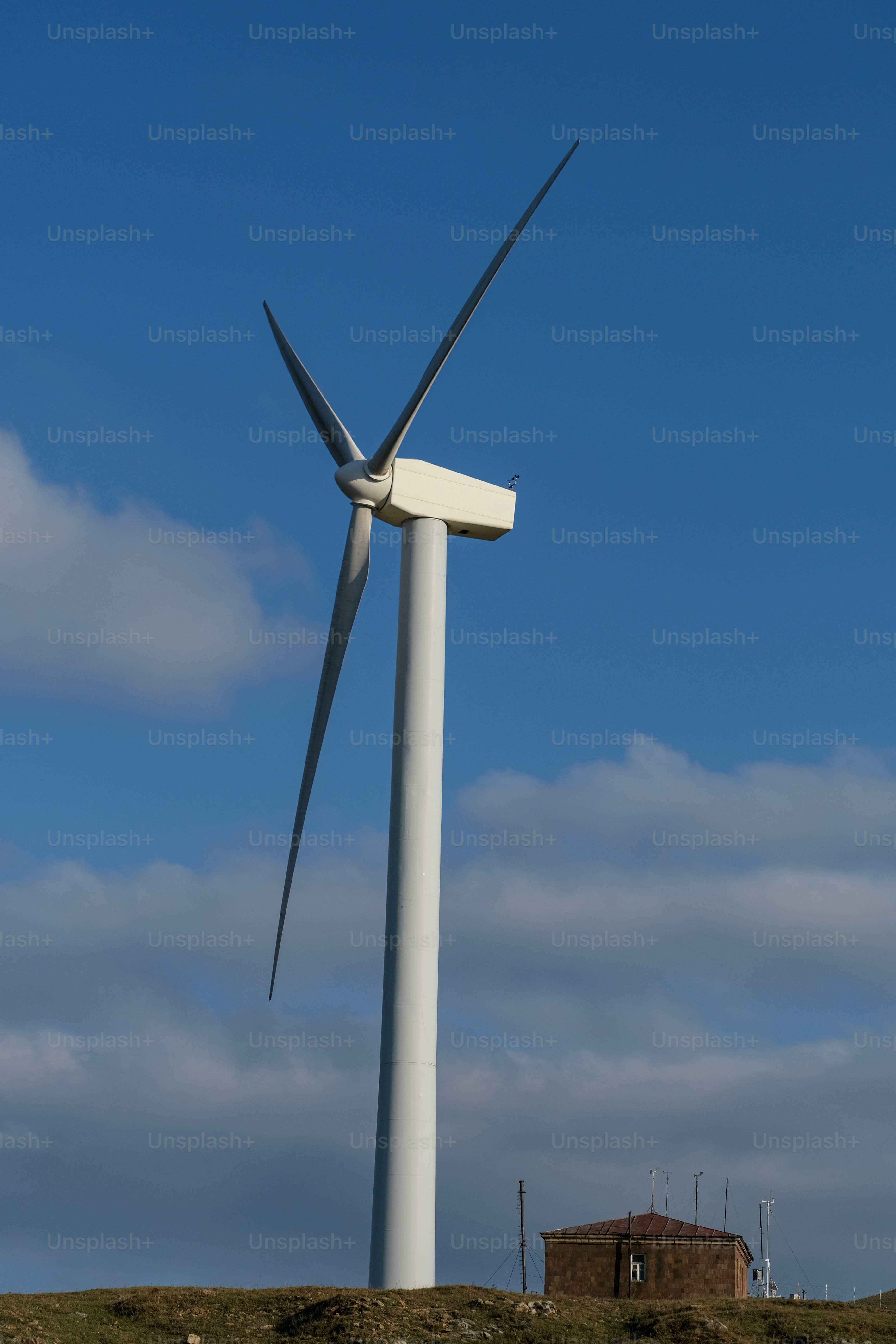 A wind farm with a wind turbine in the background photo – Wind energy ...