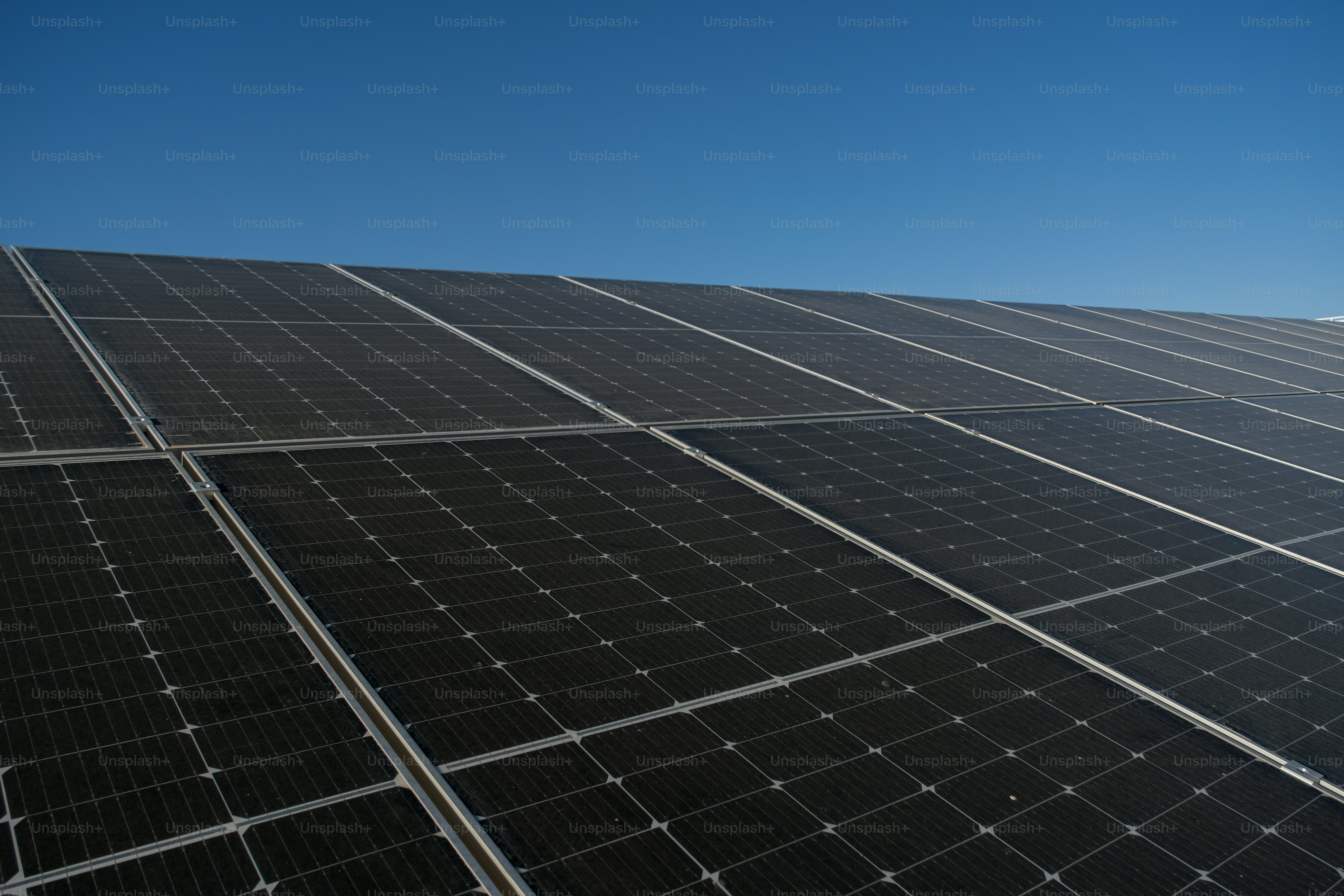 A row of rows of solar panels on a roof photo – Sustainable energy ...