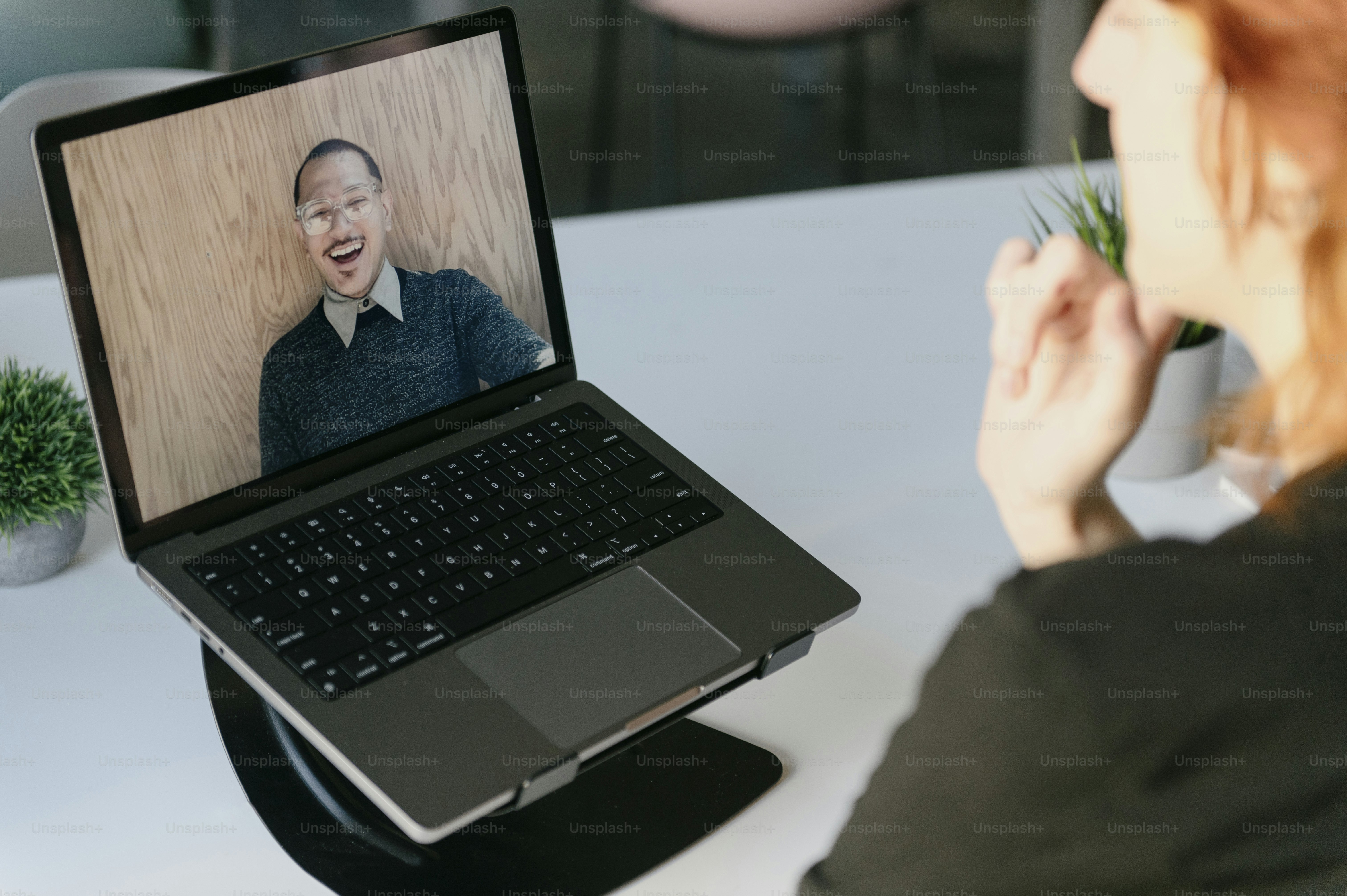 A woman sitting at a table with a laptop on her lap photo ...