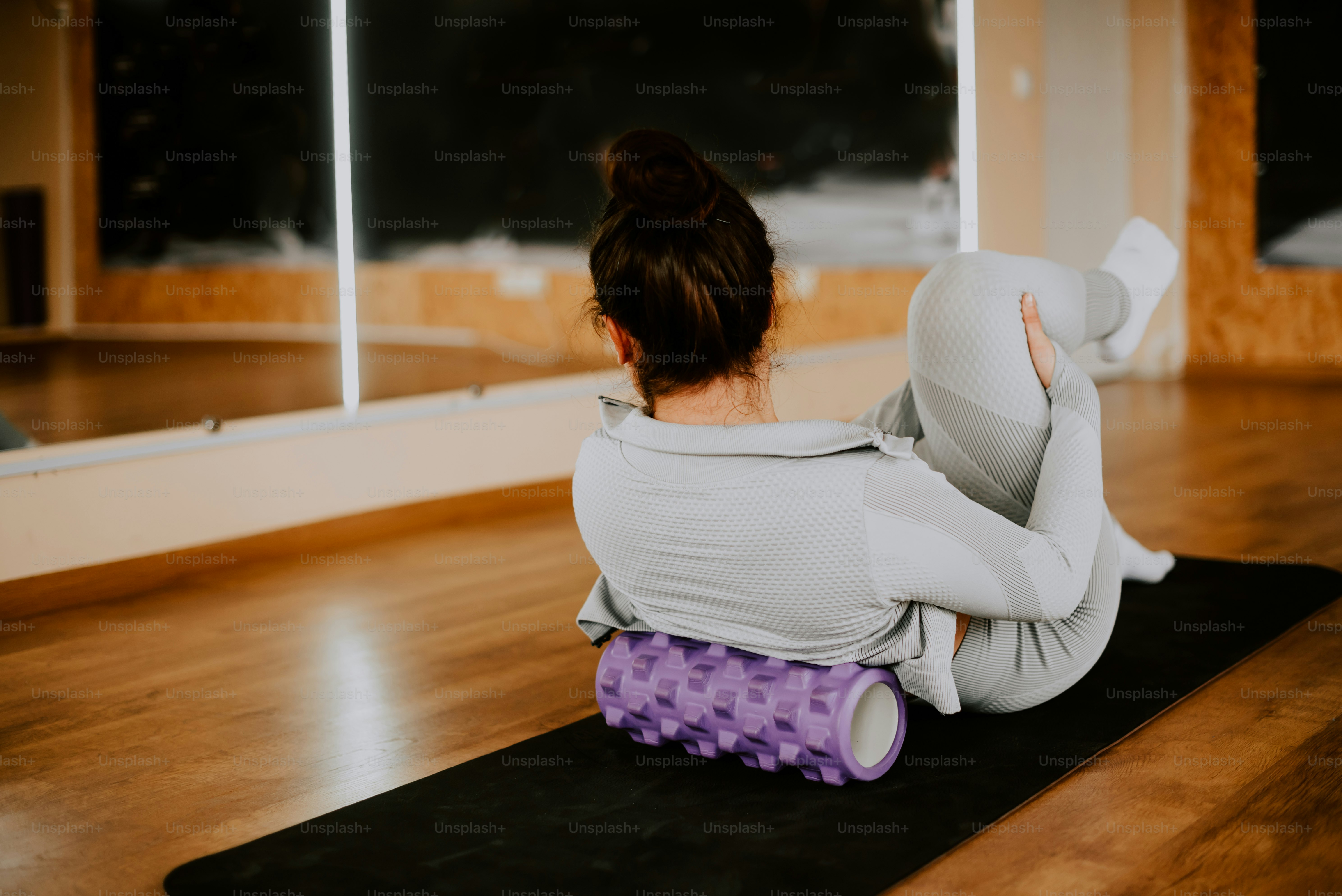 A woman sitting on a yoga mat in a room photo – Fitness Image on Unsplash