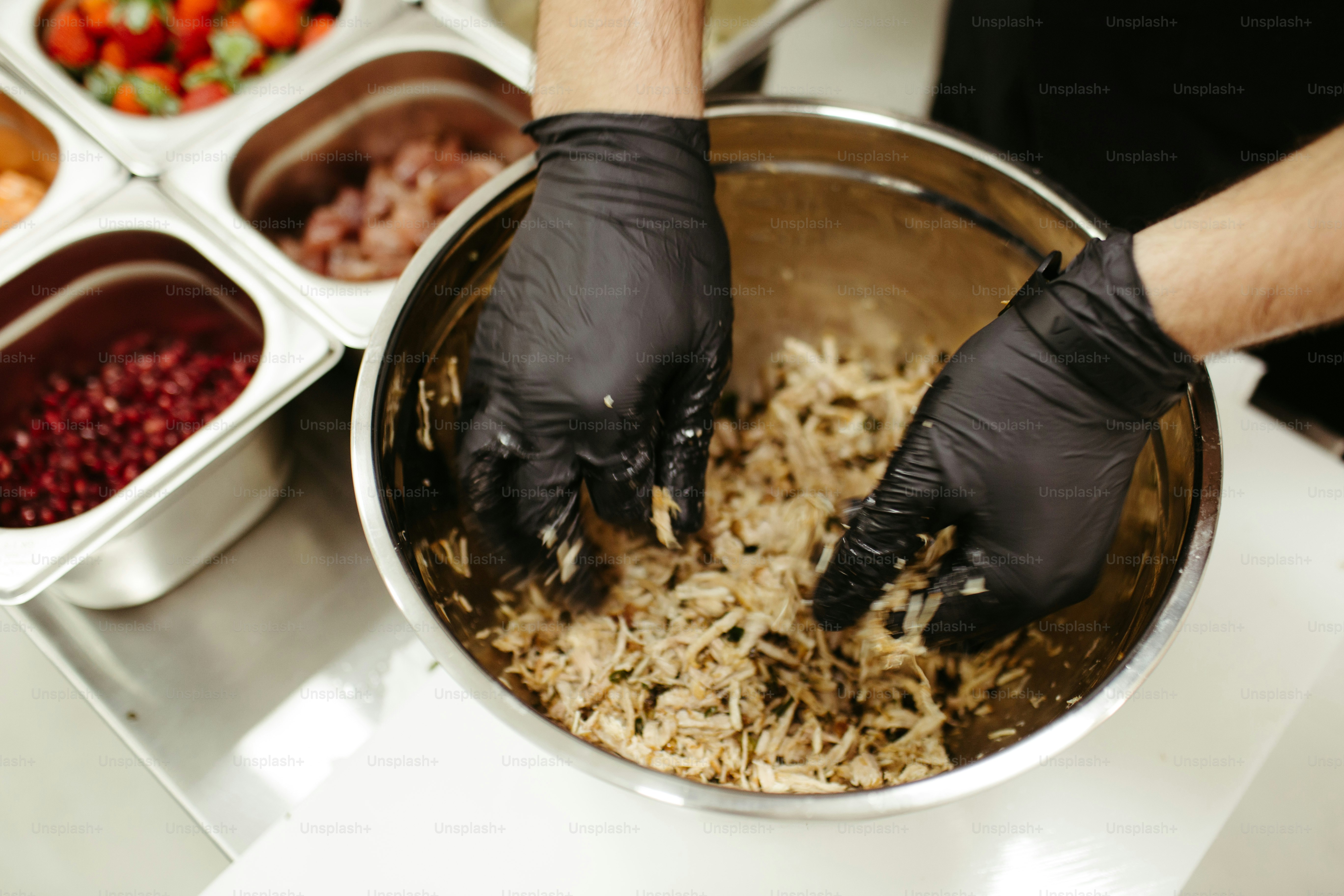 A person in black gloves cutting up food on a cutting board photo ...