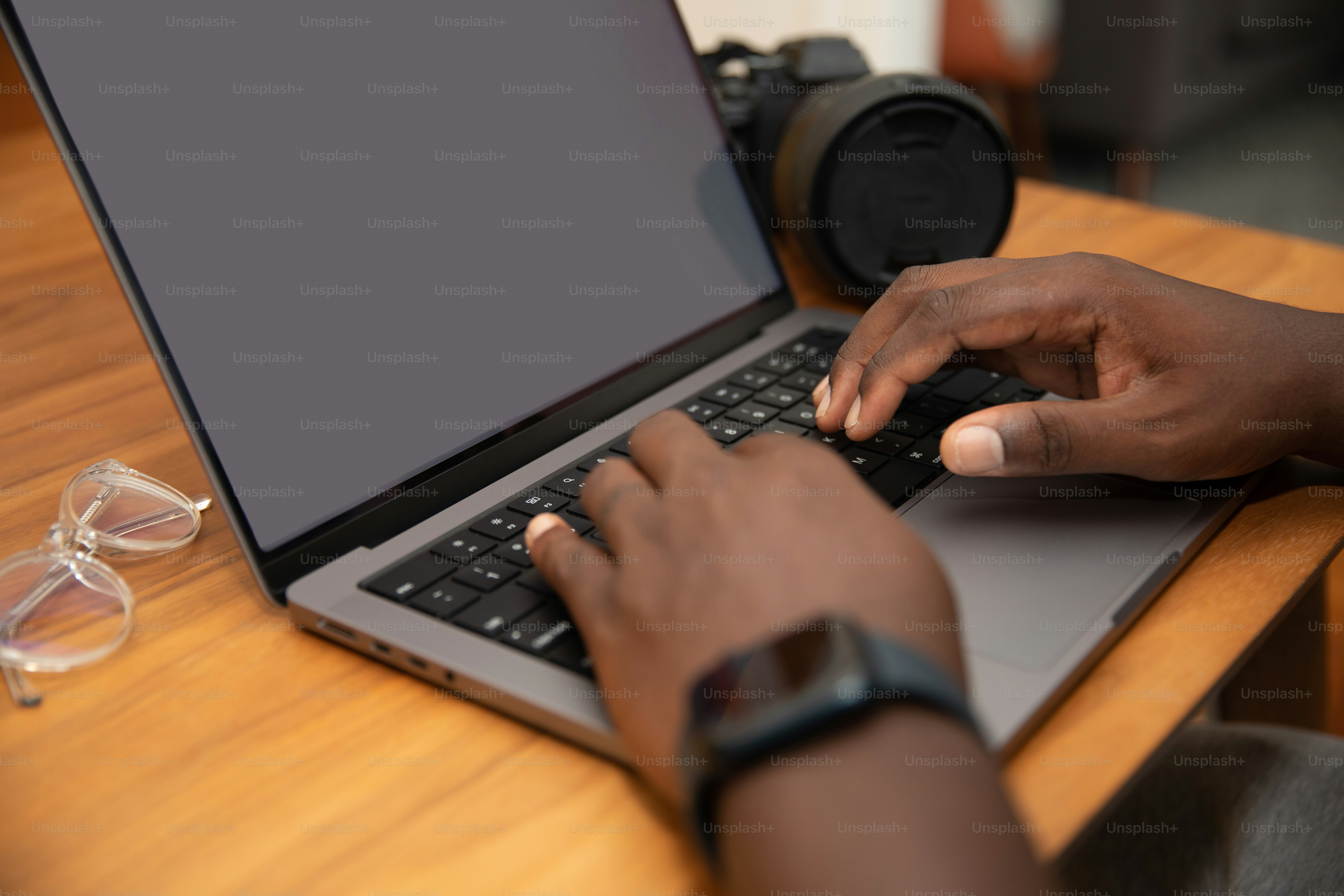 A person typing on a laptop on a wooden table photo – Technical support ...
