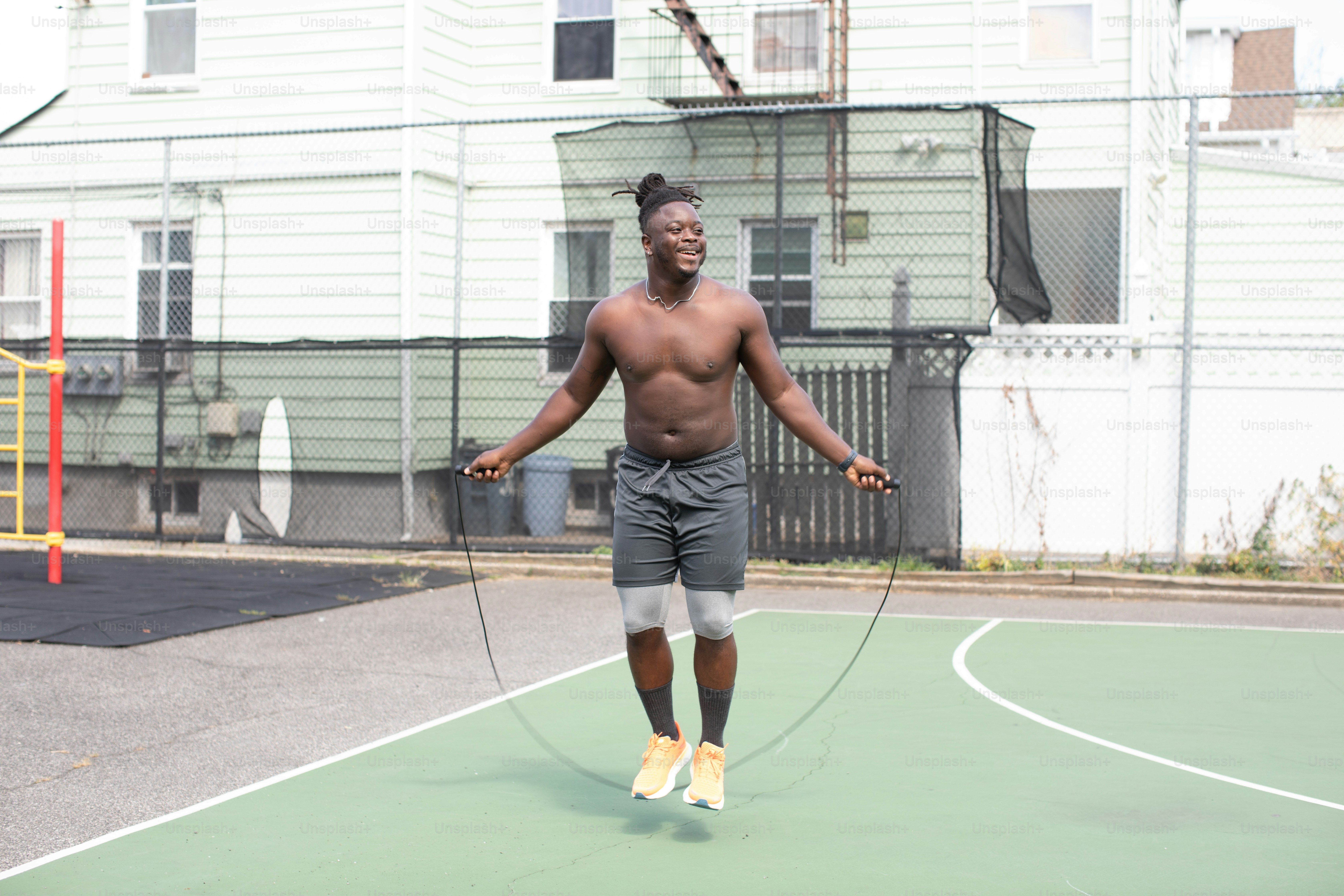 A shirtless man on a basketball court holding a rope photo – Exercise ...