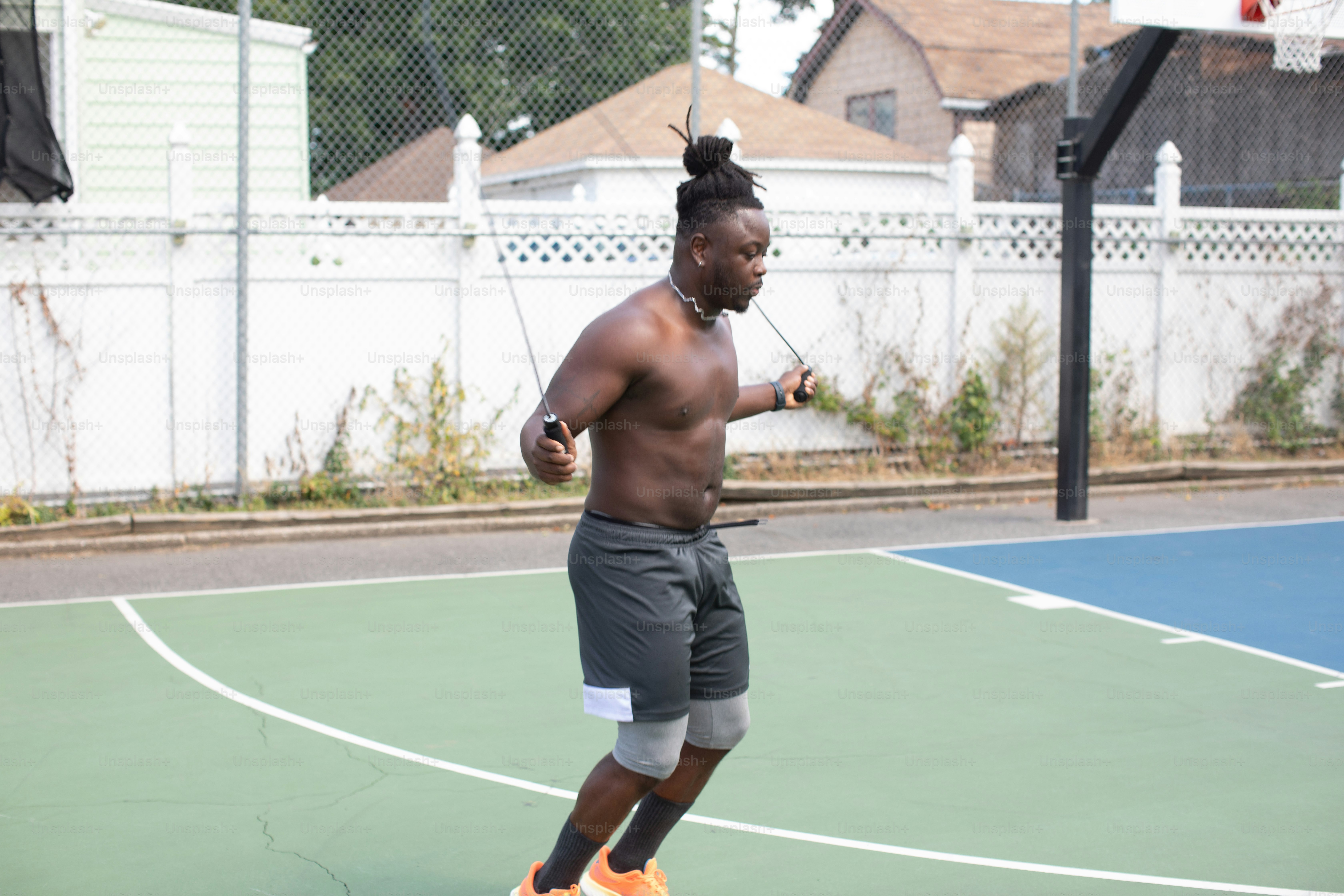 A man standing on a basketball court holding a tennis racquet photo ...
