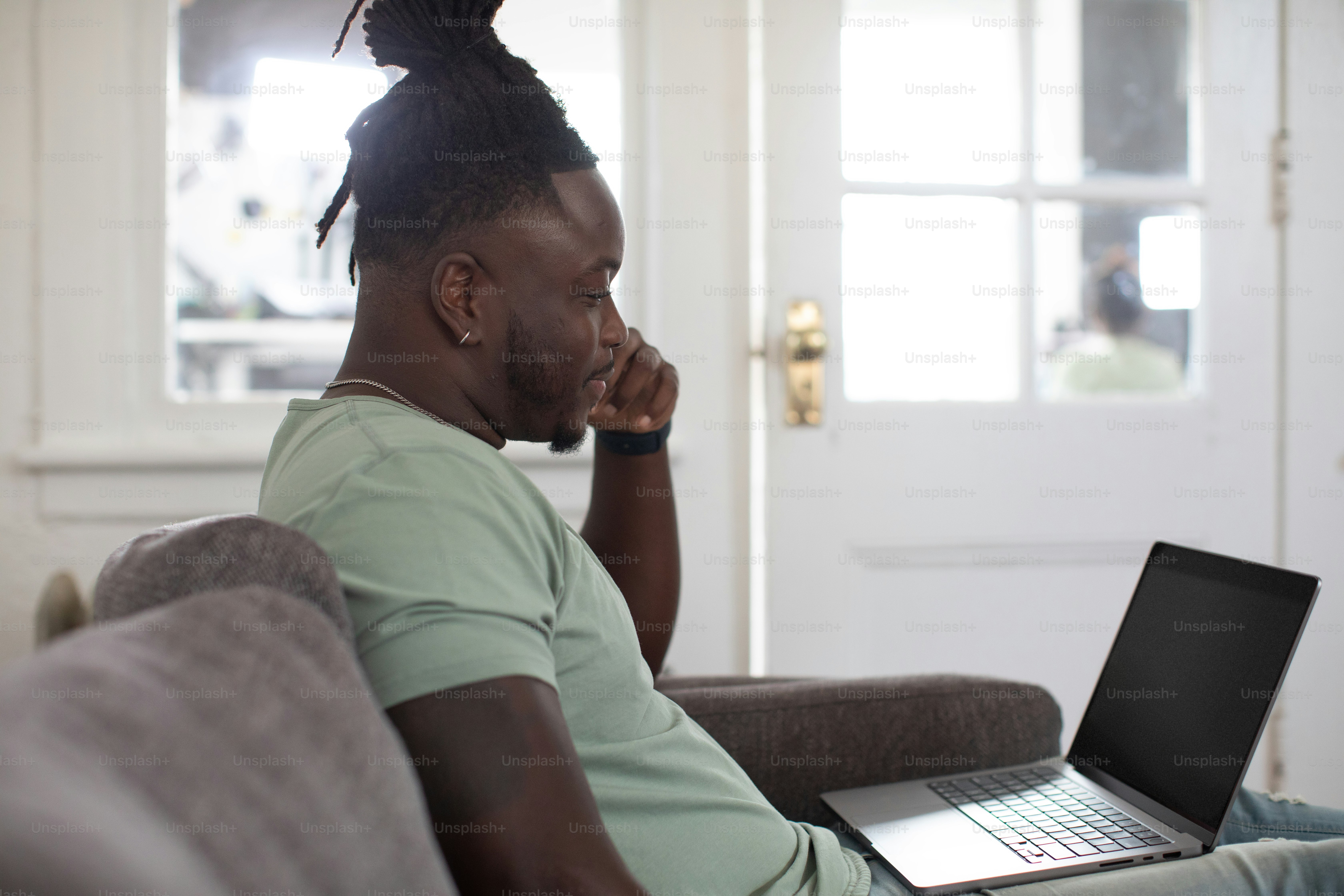 A man sitting on a couch using a laptop computer photo – Person thinking Image on Unsplash