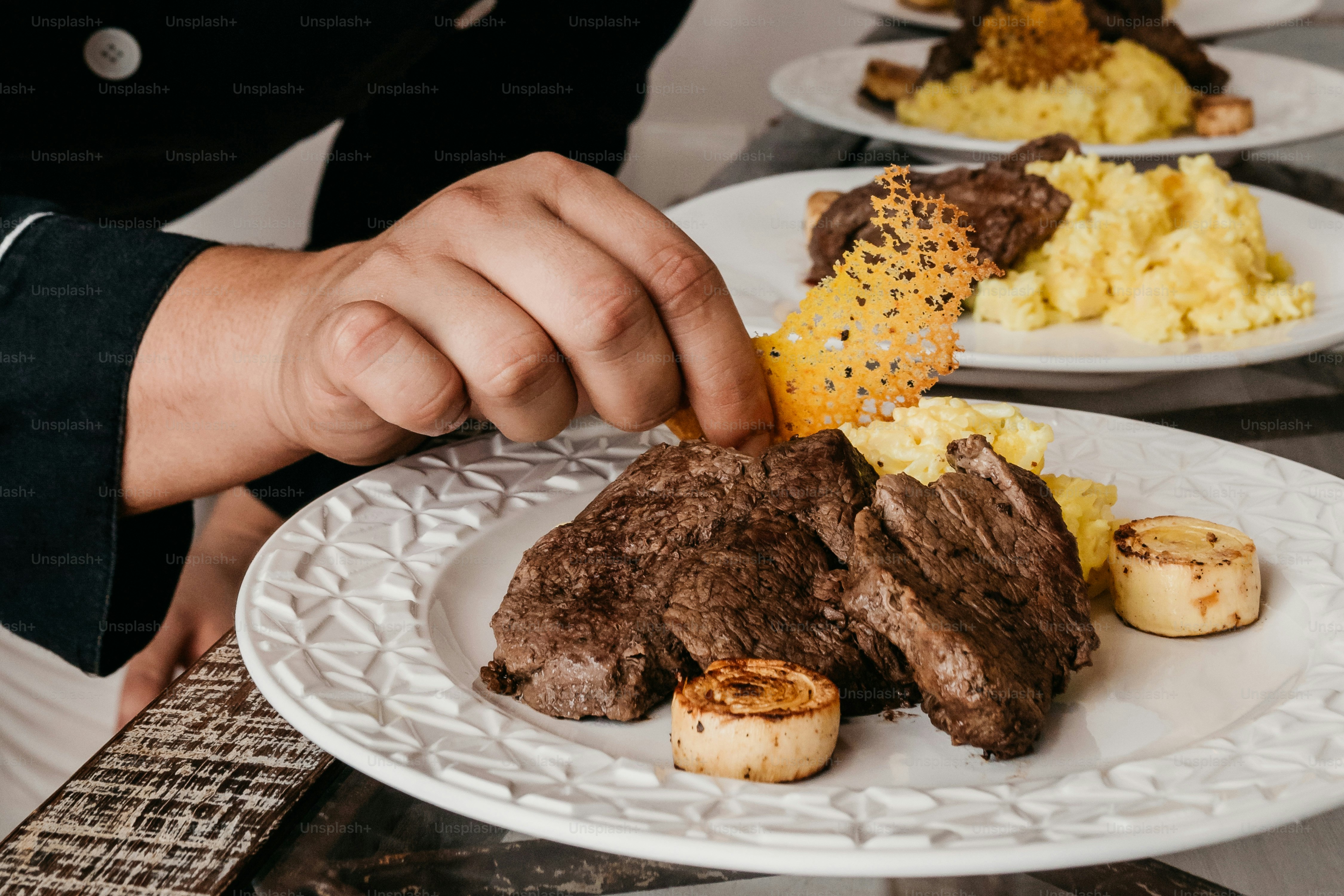 A person is cutting into a plate of food photo – Western food Image on ...