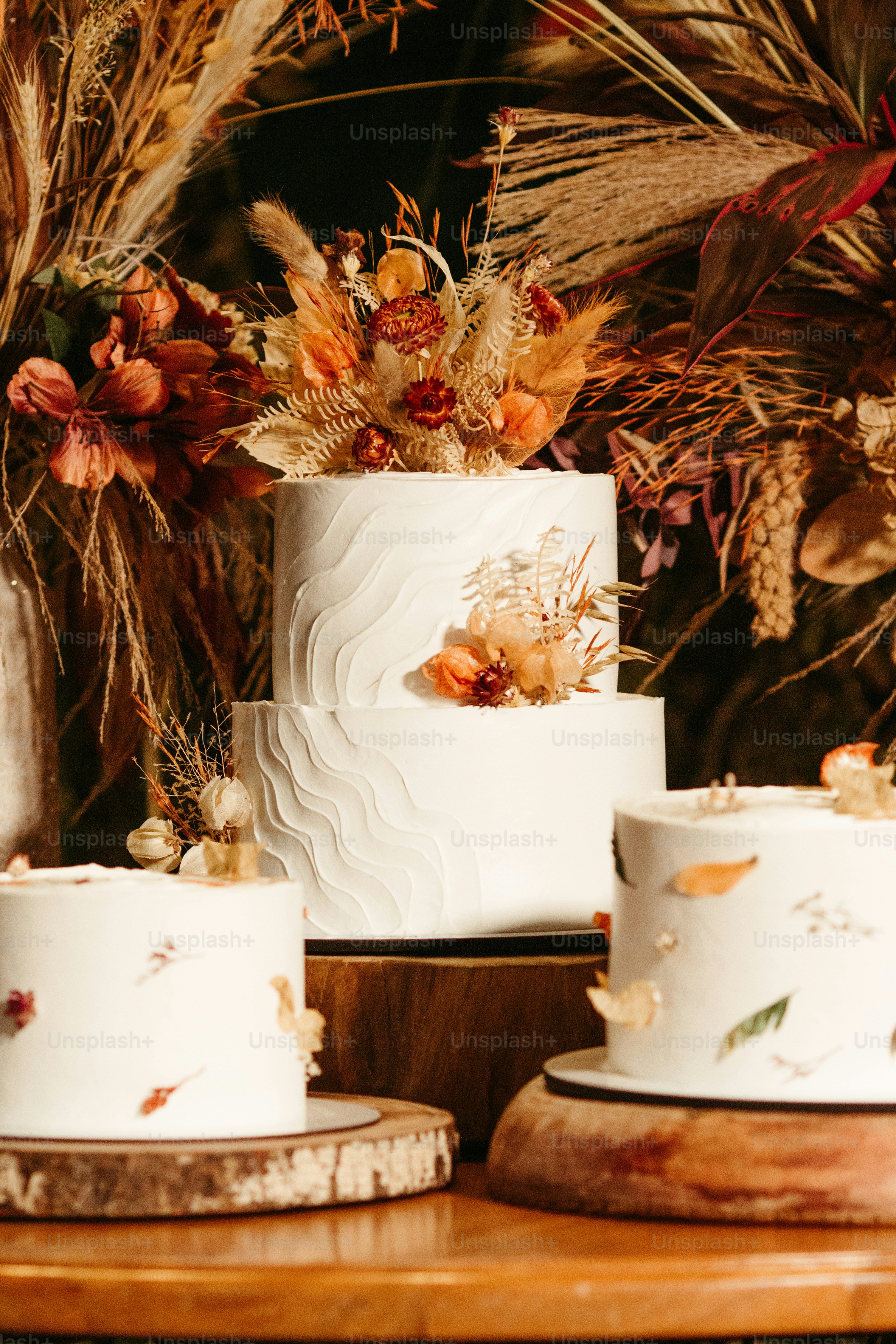 A close up of a three tiered cake on a table photo – Wedding cakes ...