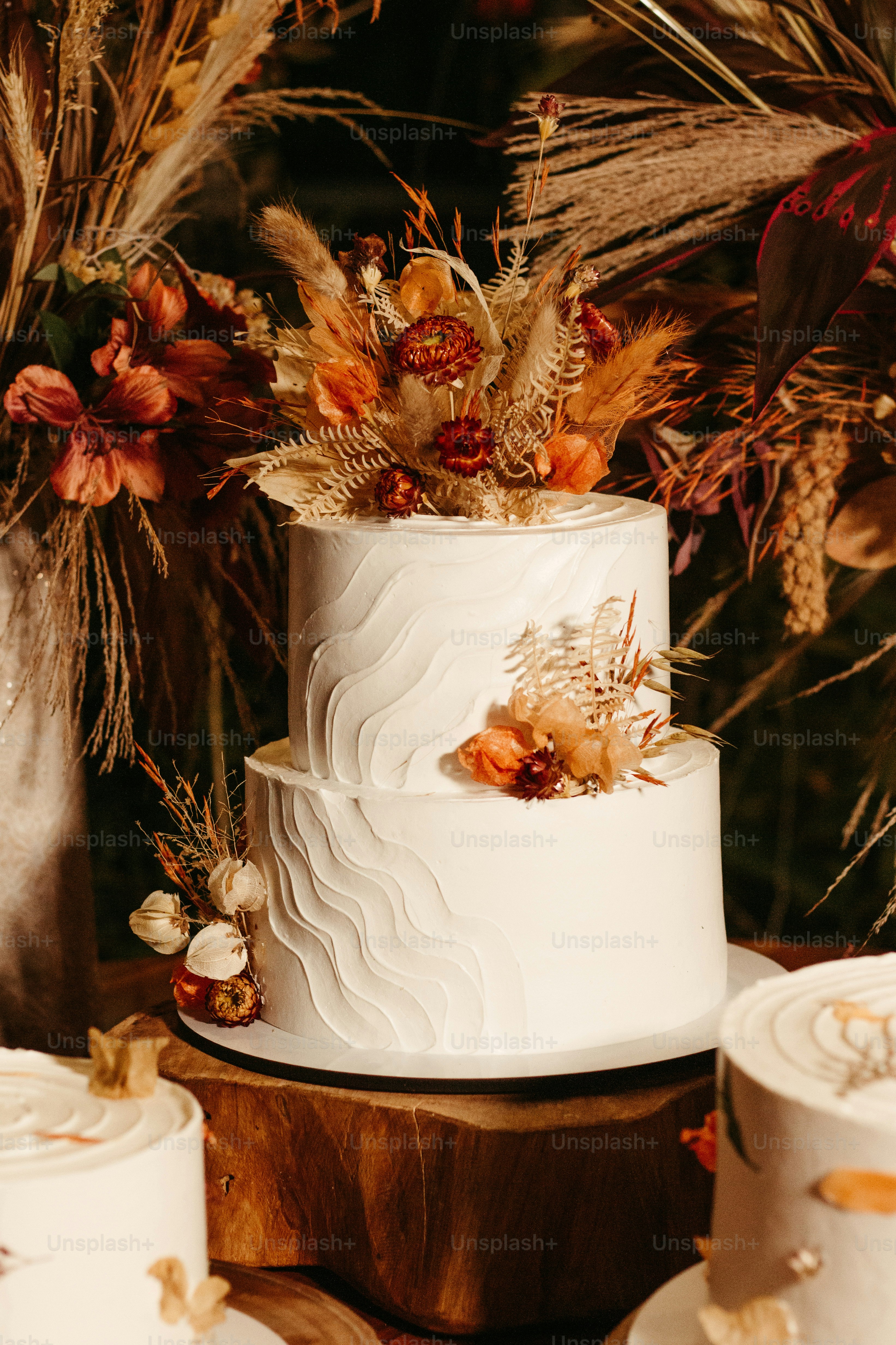 A three tiered white wedding cake sitting on top of a wooden table ...