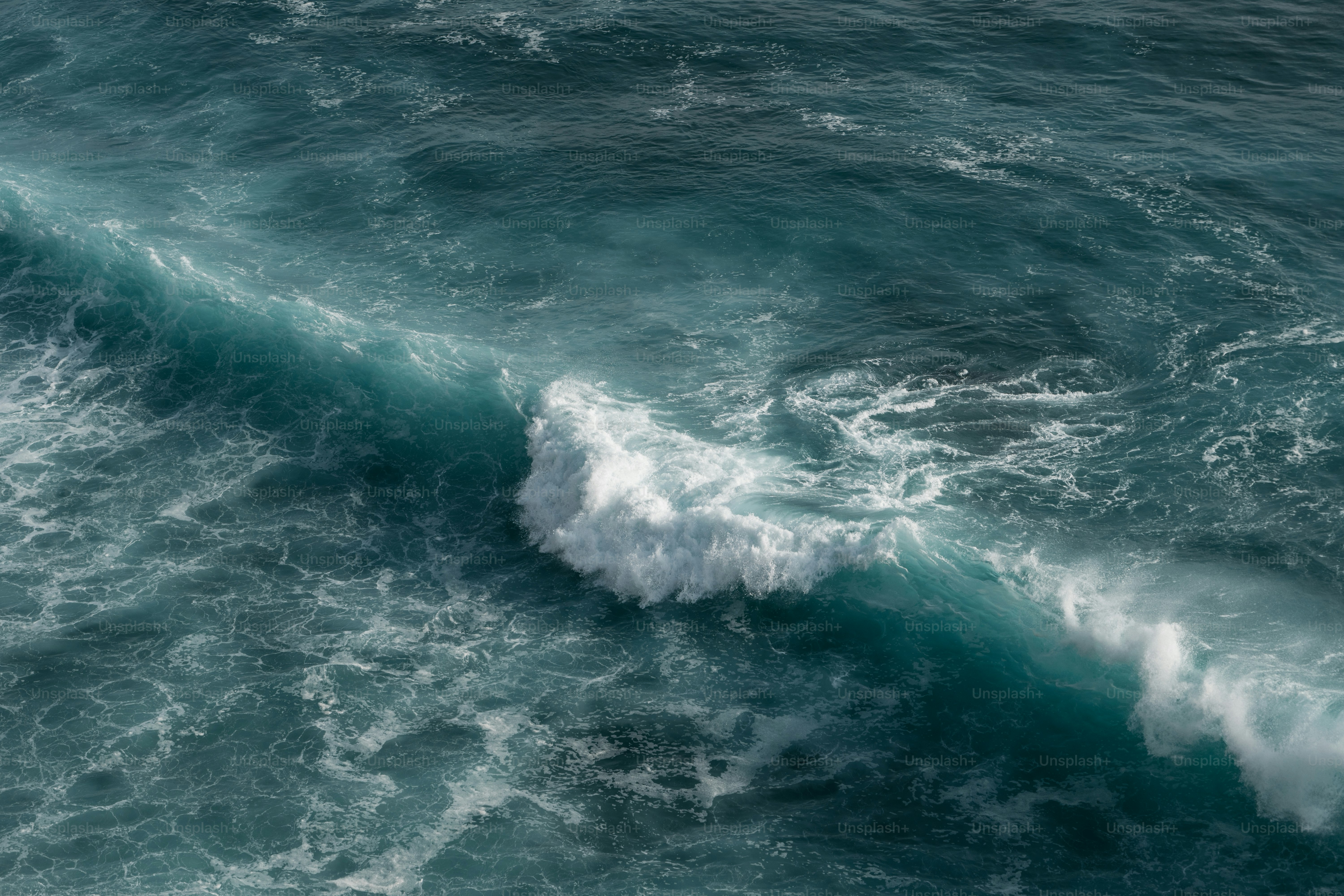 A large wave breaking over the top of the ocean photo – Beach Image on ...
