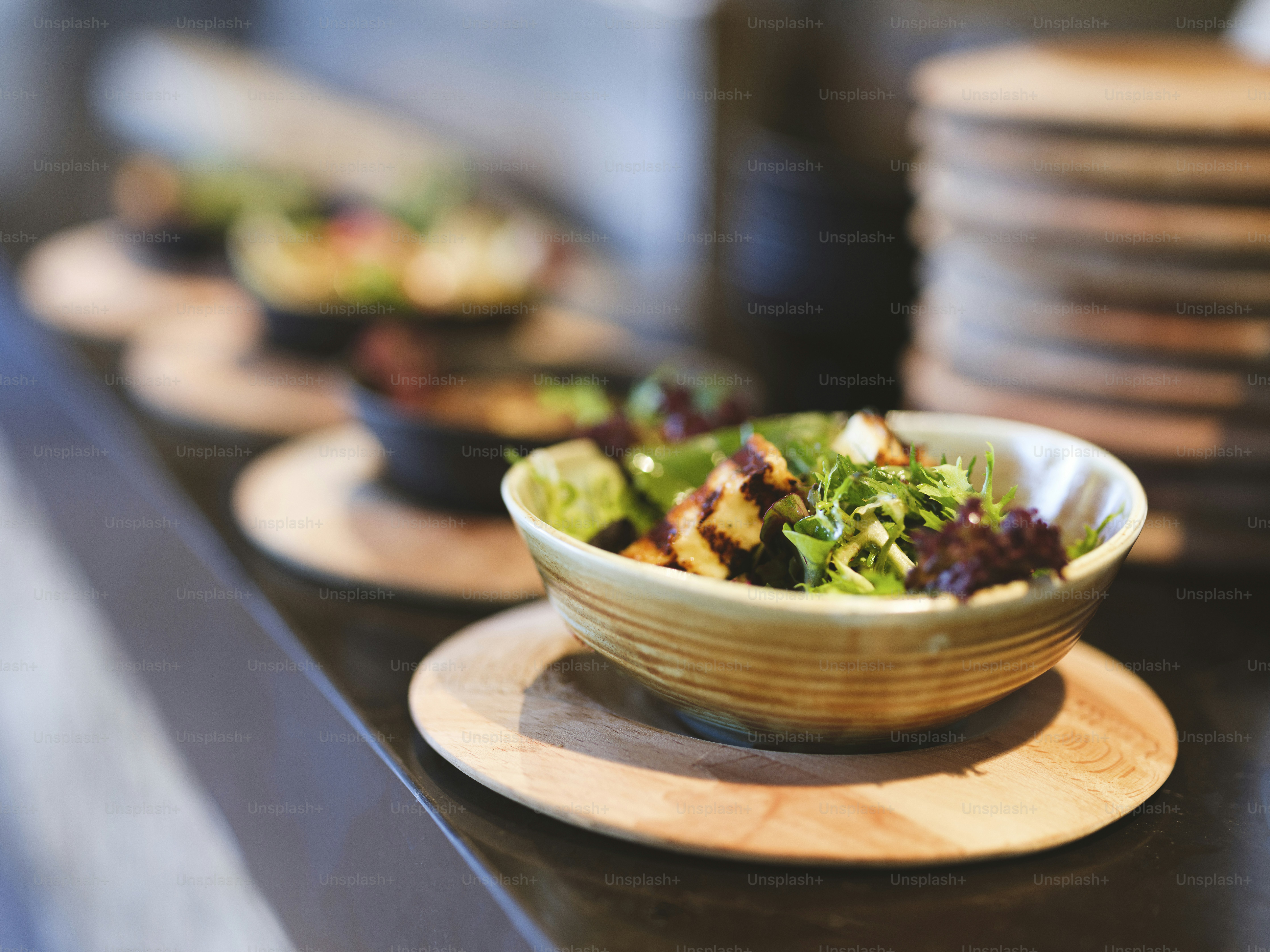 A bowl of salad sitting on top of a wooden plate photo – Healthy Image ...