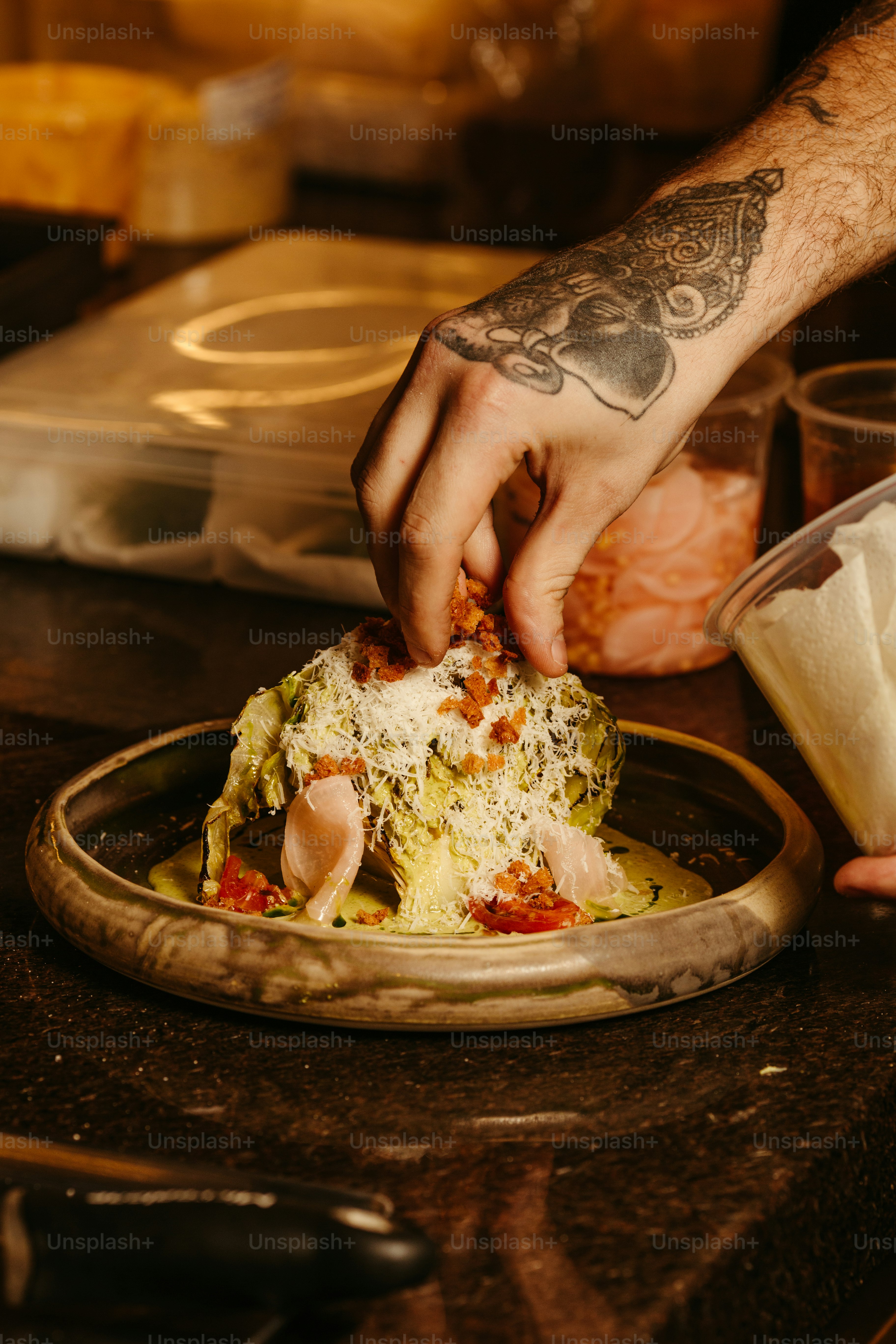 A person putting something on top of a plate photo – Cooking Image on ...