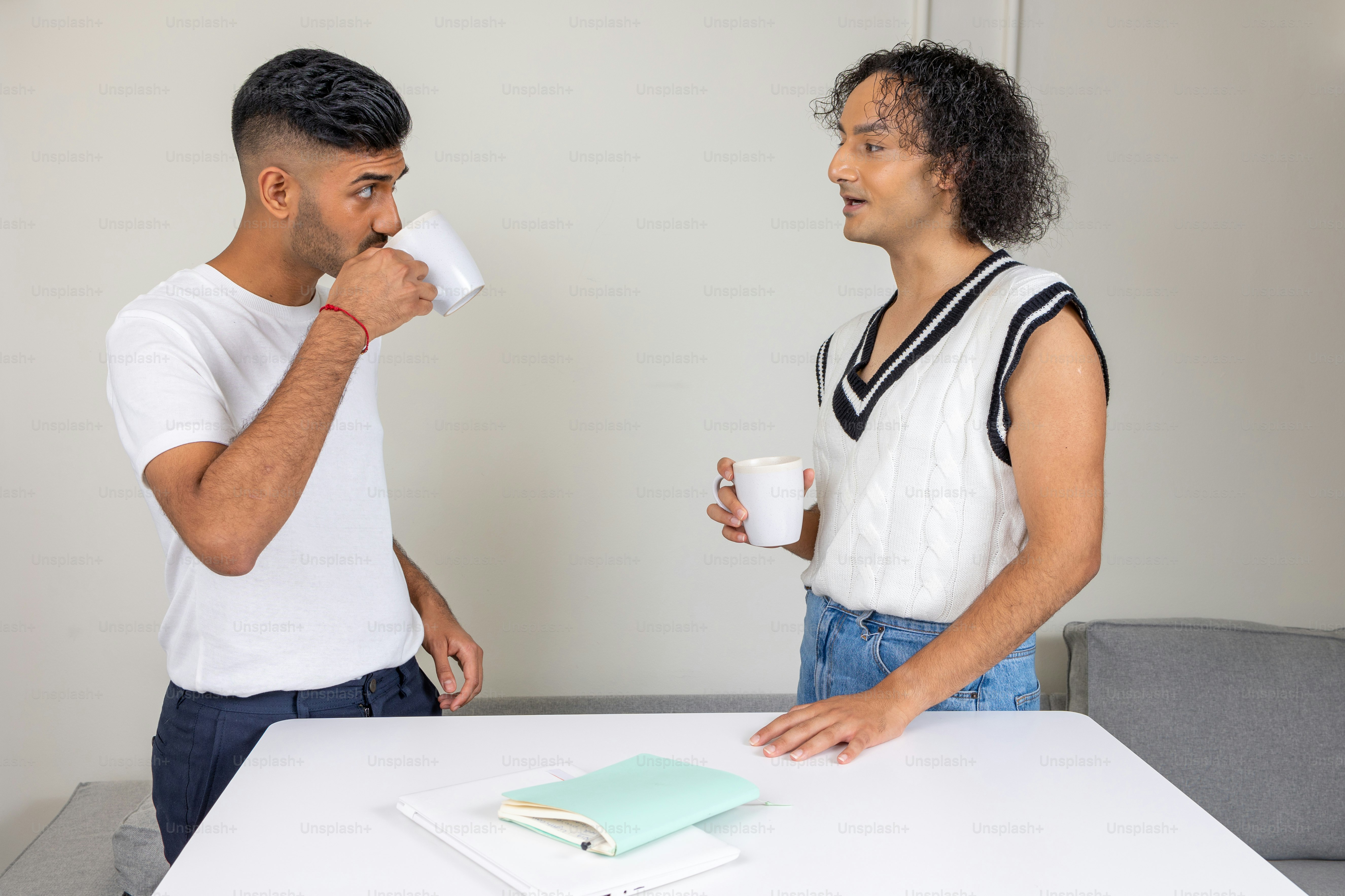 A couple of people standing around a table photo – Business Image on ...