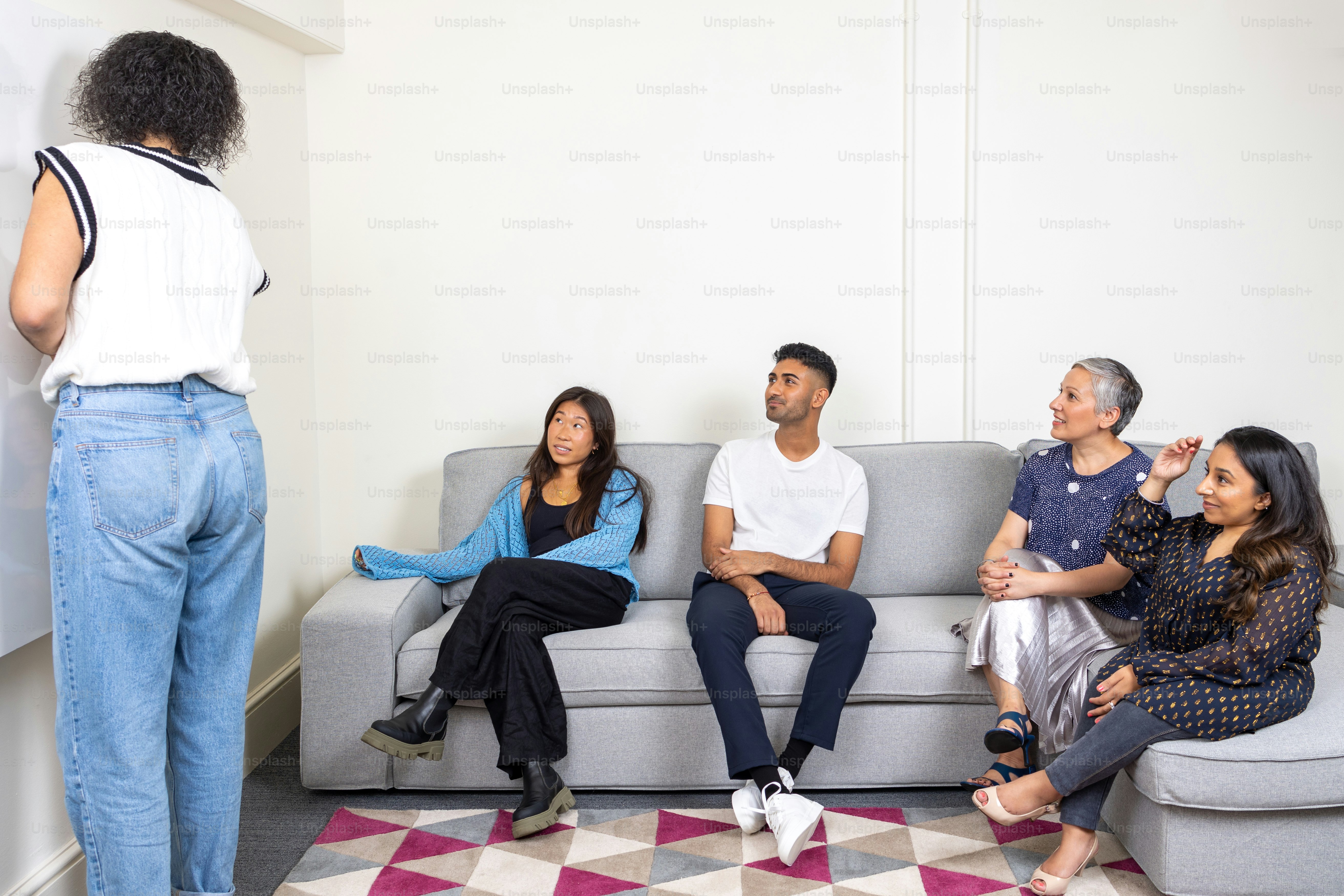 Un groupe de personnes assises sur un canapé photo – Personnes Photo ...